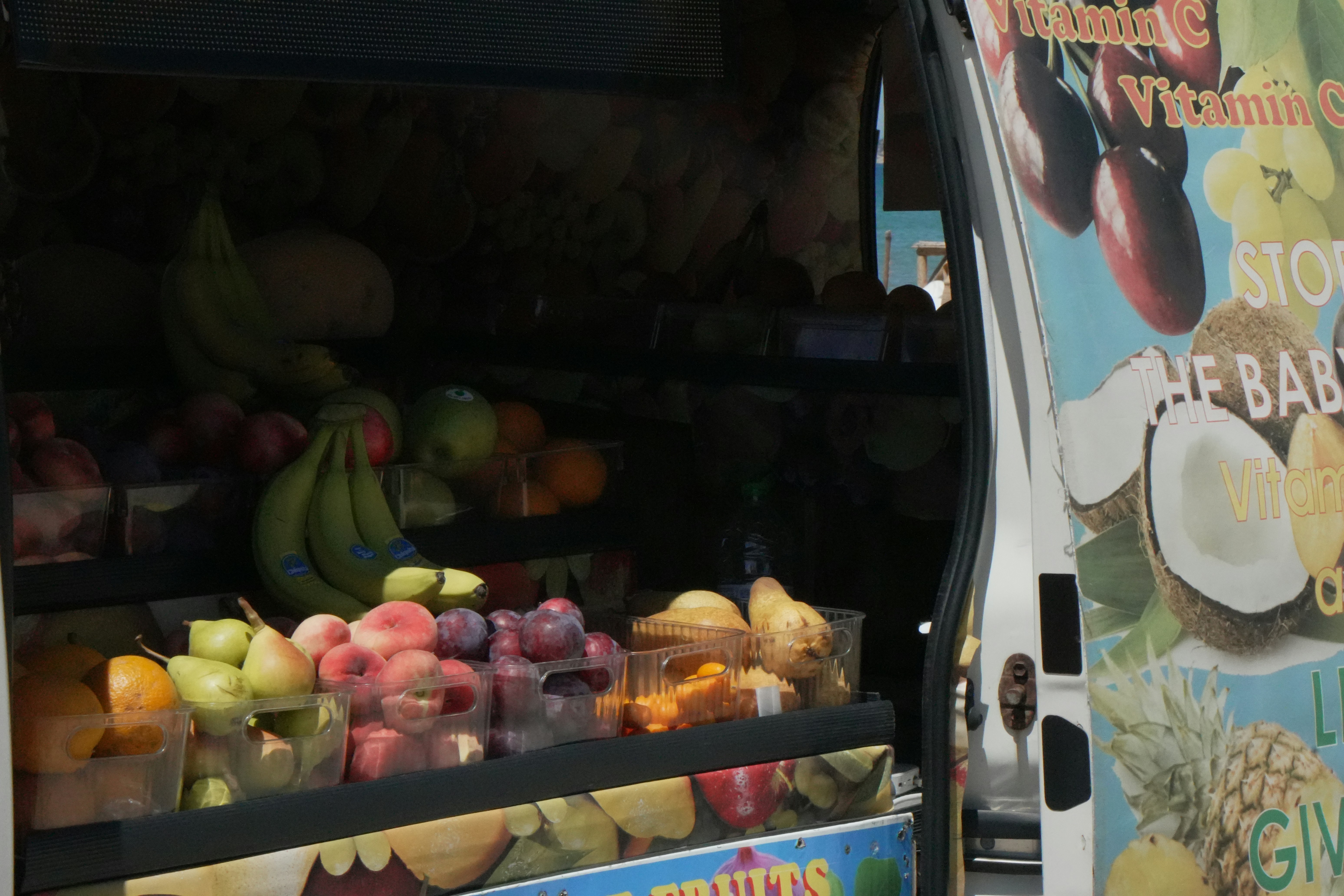 Fruit Cart Near a van: A Quiet Marketplace Moment