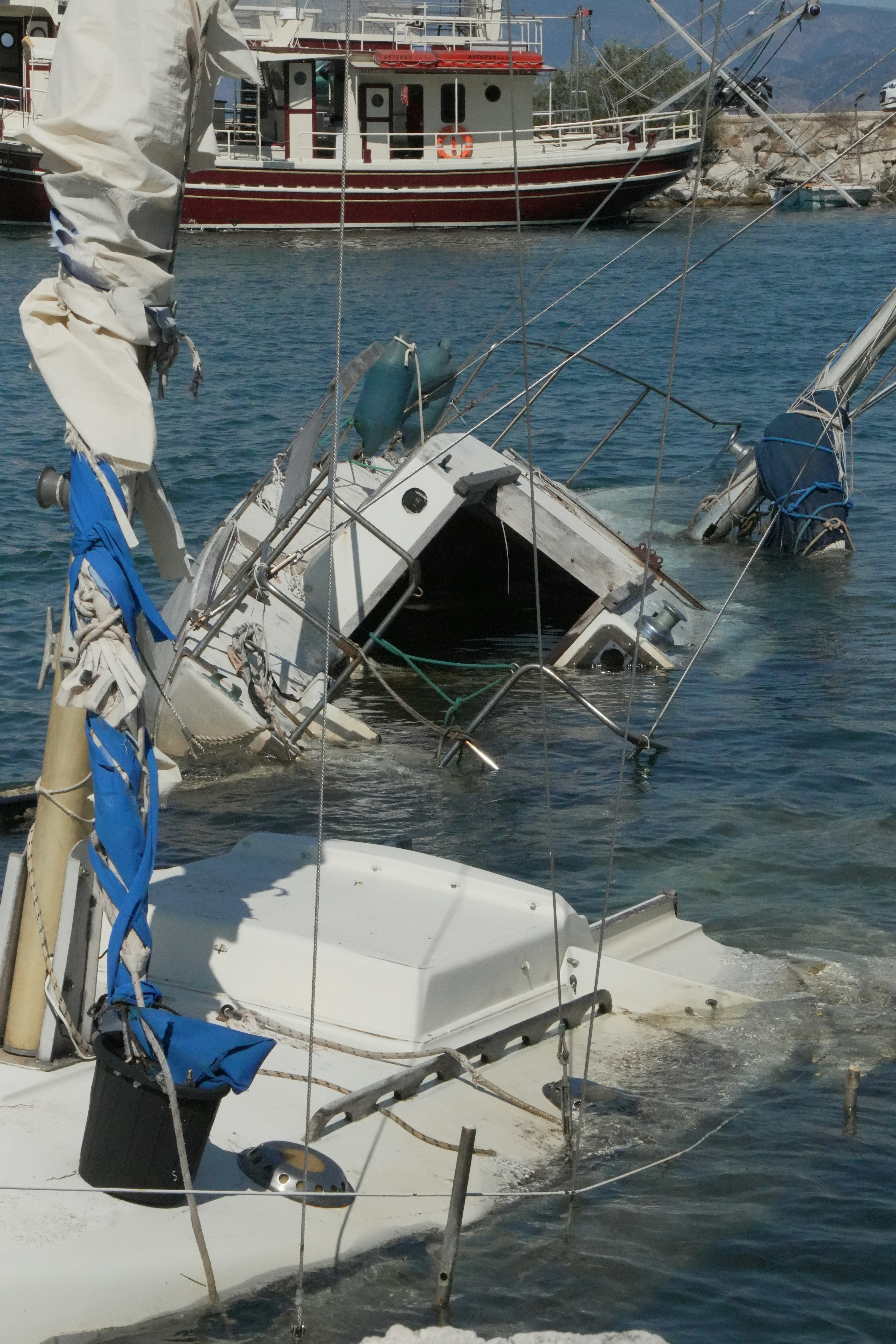 Sunken Sailboat in Calm Harbor: Frail Masts and Quiet Currents