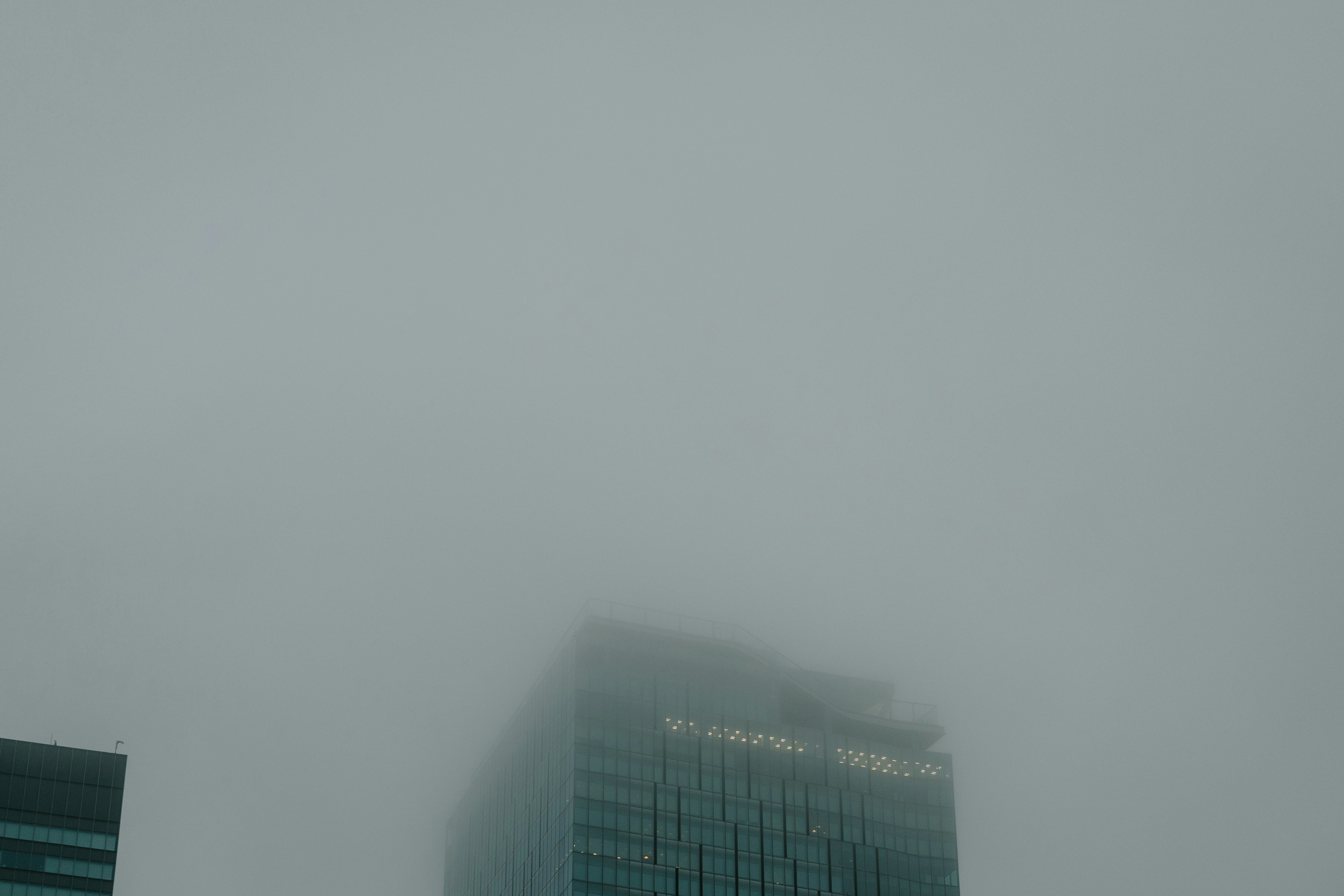 Fog-Engulfed Skyscraper Emerges from the Grey Veil