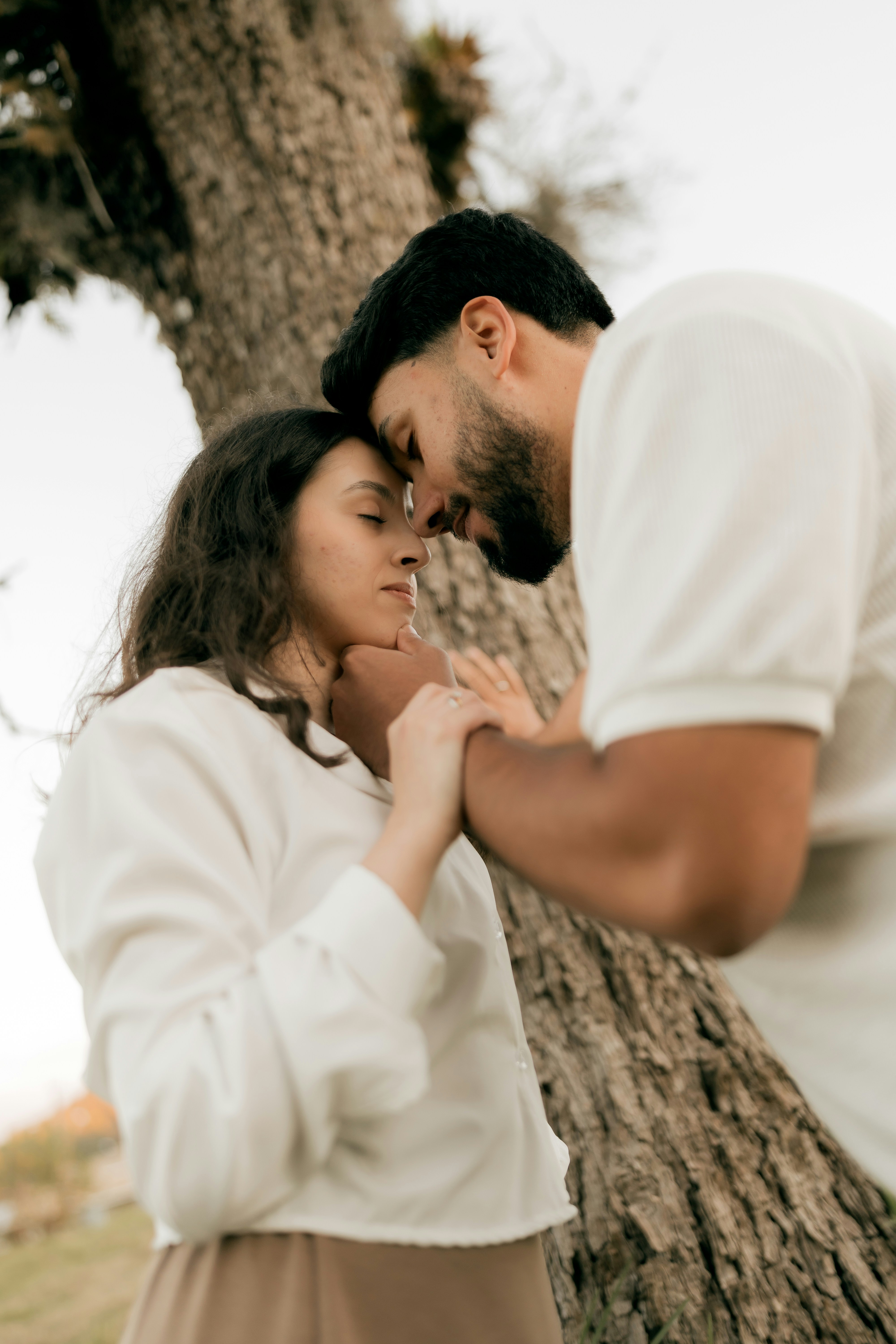Foreheads Touch: Tender Moment Beneath a Ancient Tree