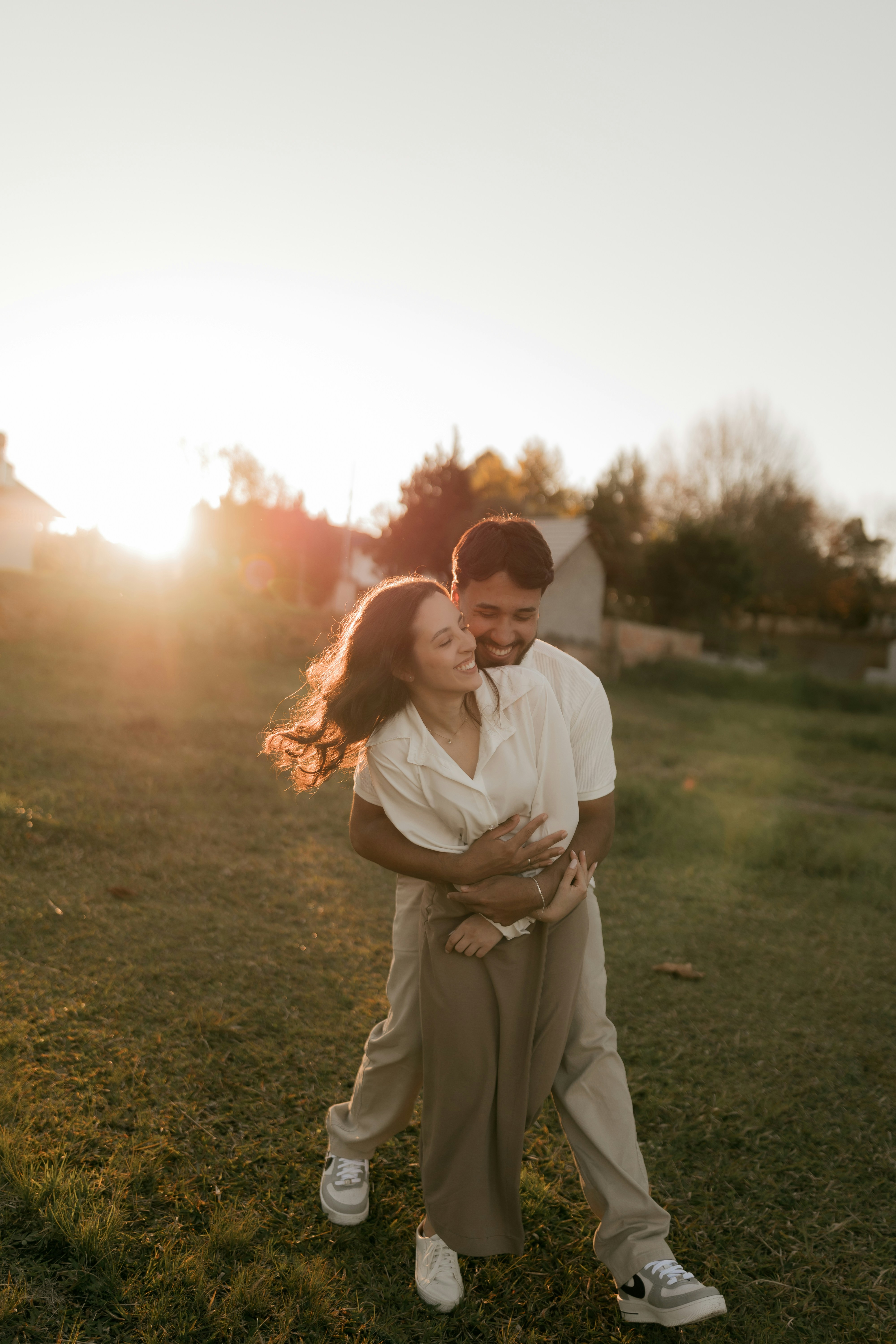 Sunlit embrace: a couple share a playful moment at golden hour