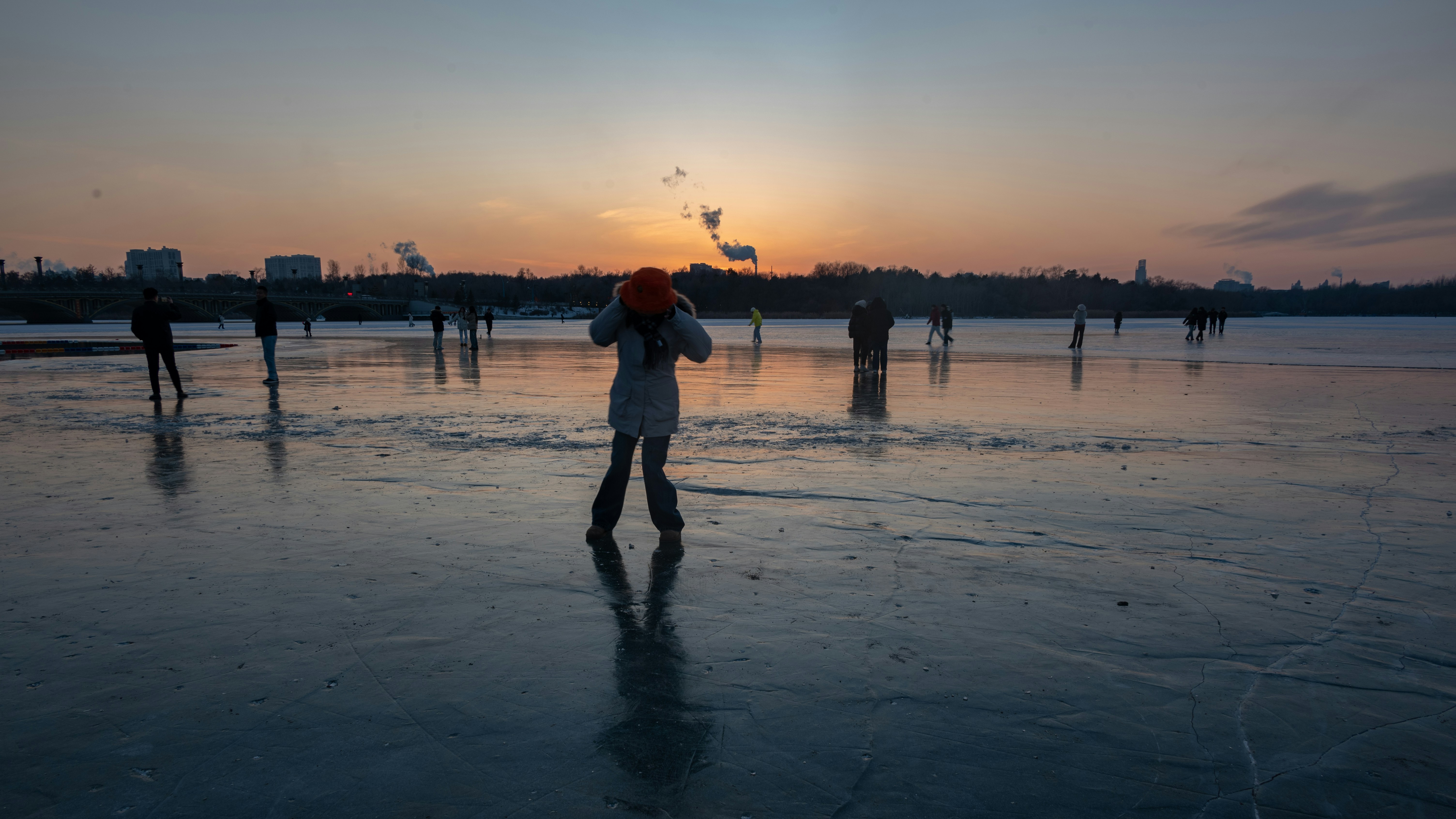 Sunset on the Frozen Plain: A Lone Explorer Amid Silhouetted Figures