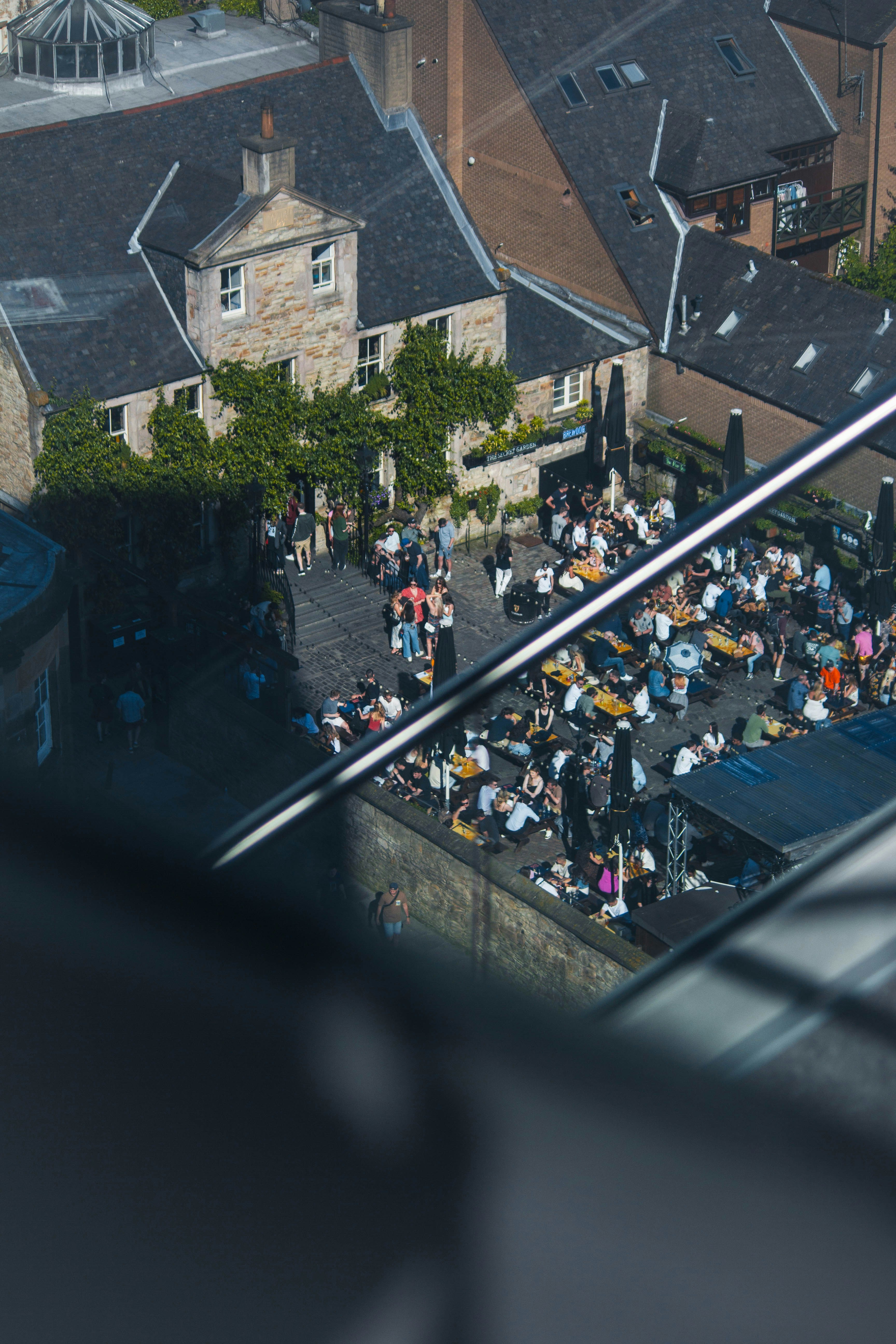 A Courtyard Rendezvous: People Gathered Beneath Rooftops Seen from Above