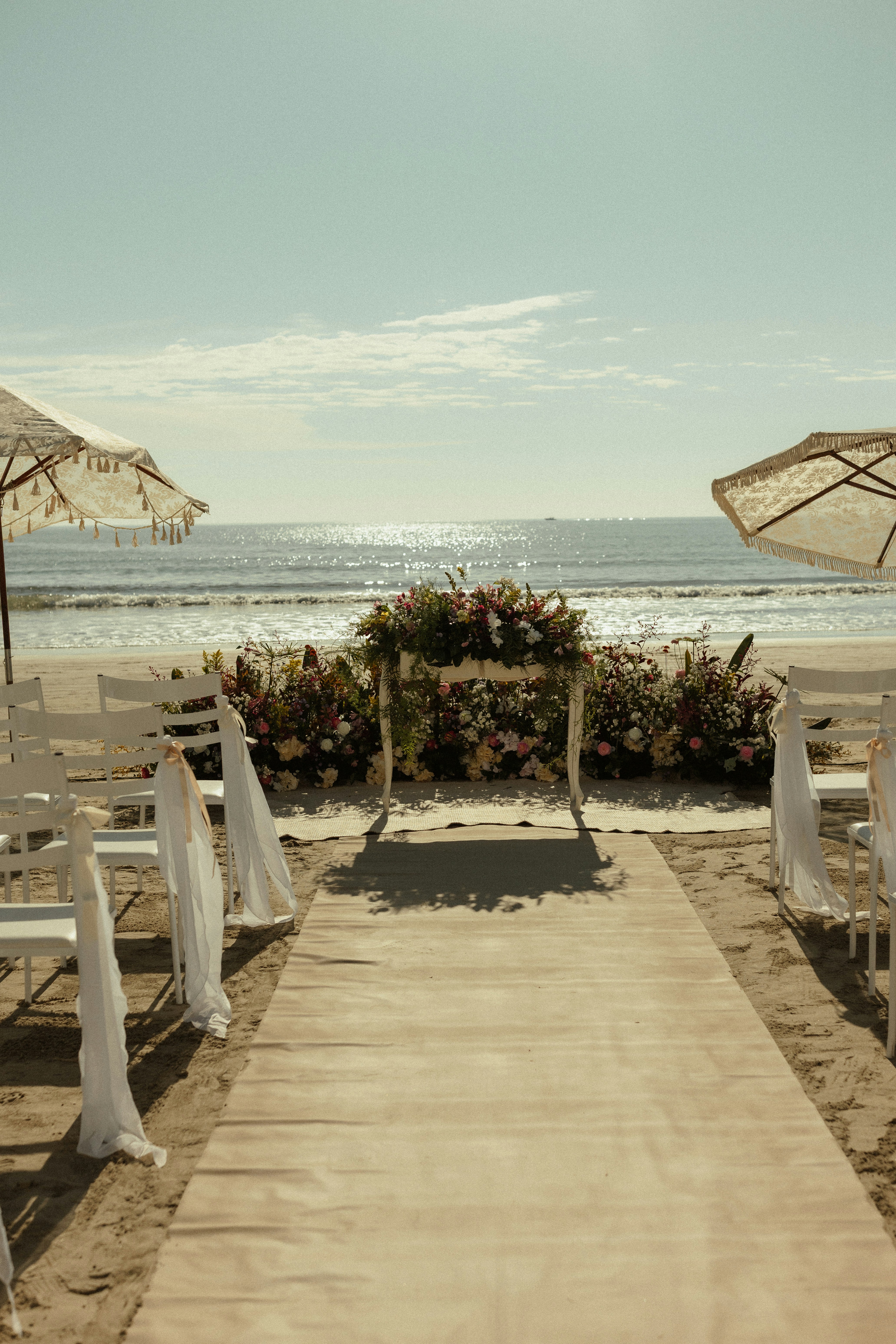 Sunlit Beach Aisle: Floral Altar Over Oceanfront Sands