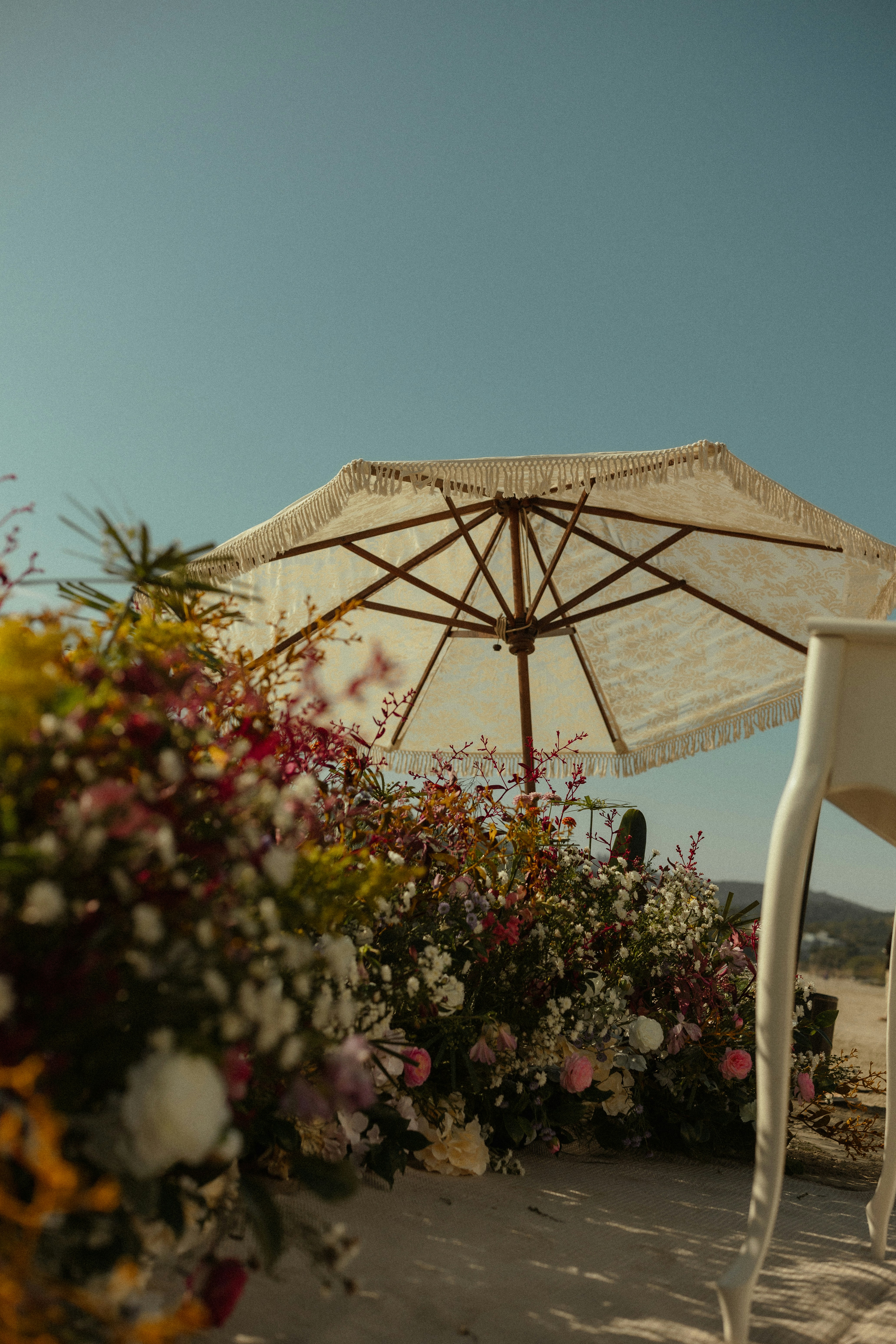 Sunlit Terrace with Flowering Bed and Fringed Parasol