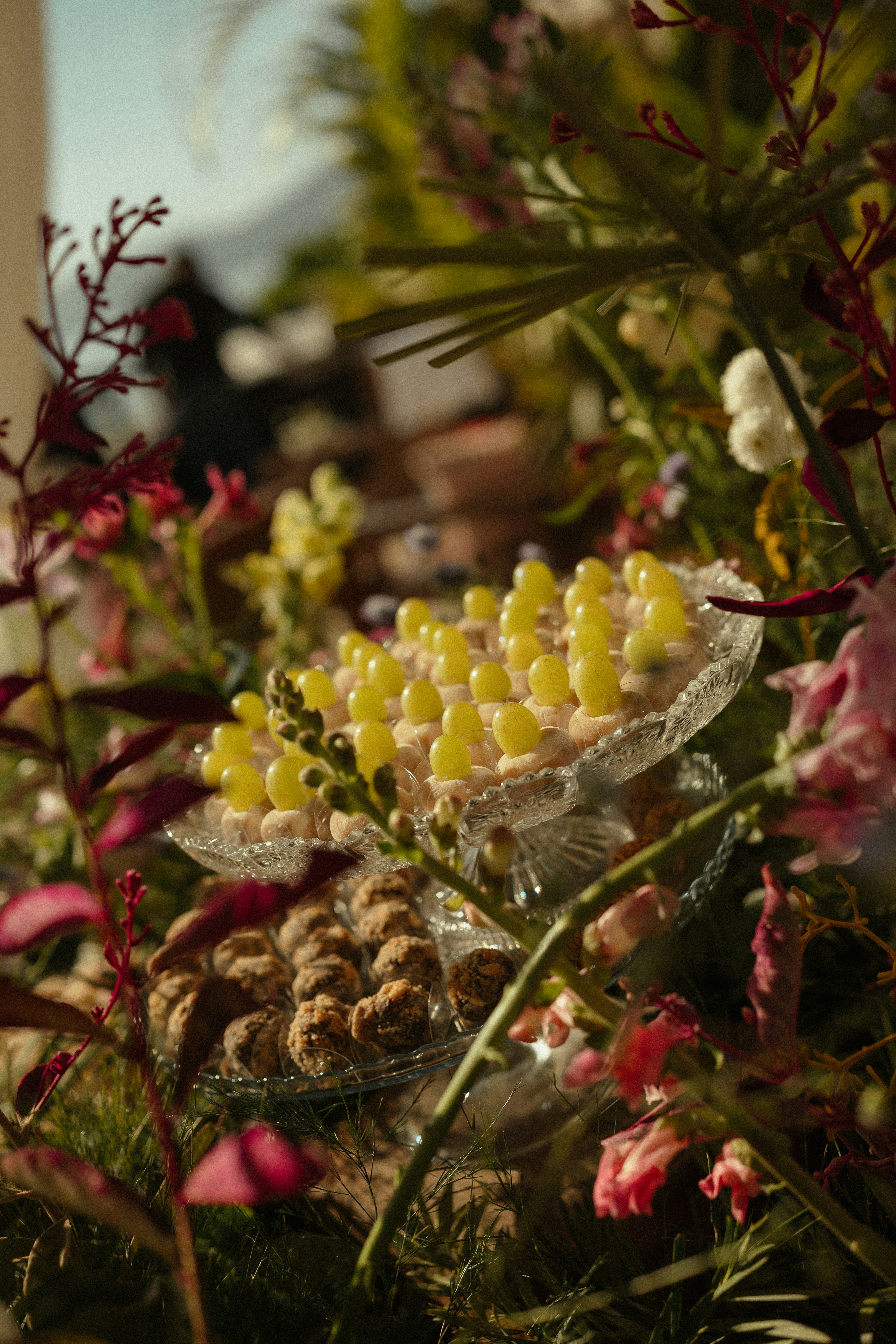 Yellow grape-like beads on a crystal dish surrounded by floral chaos
