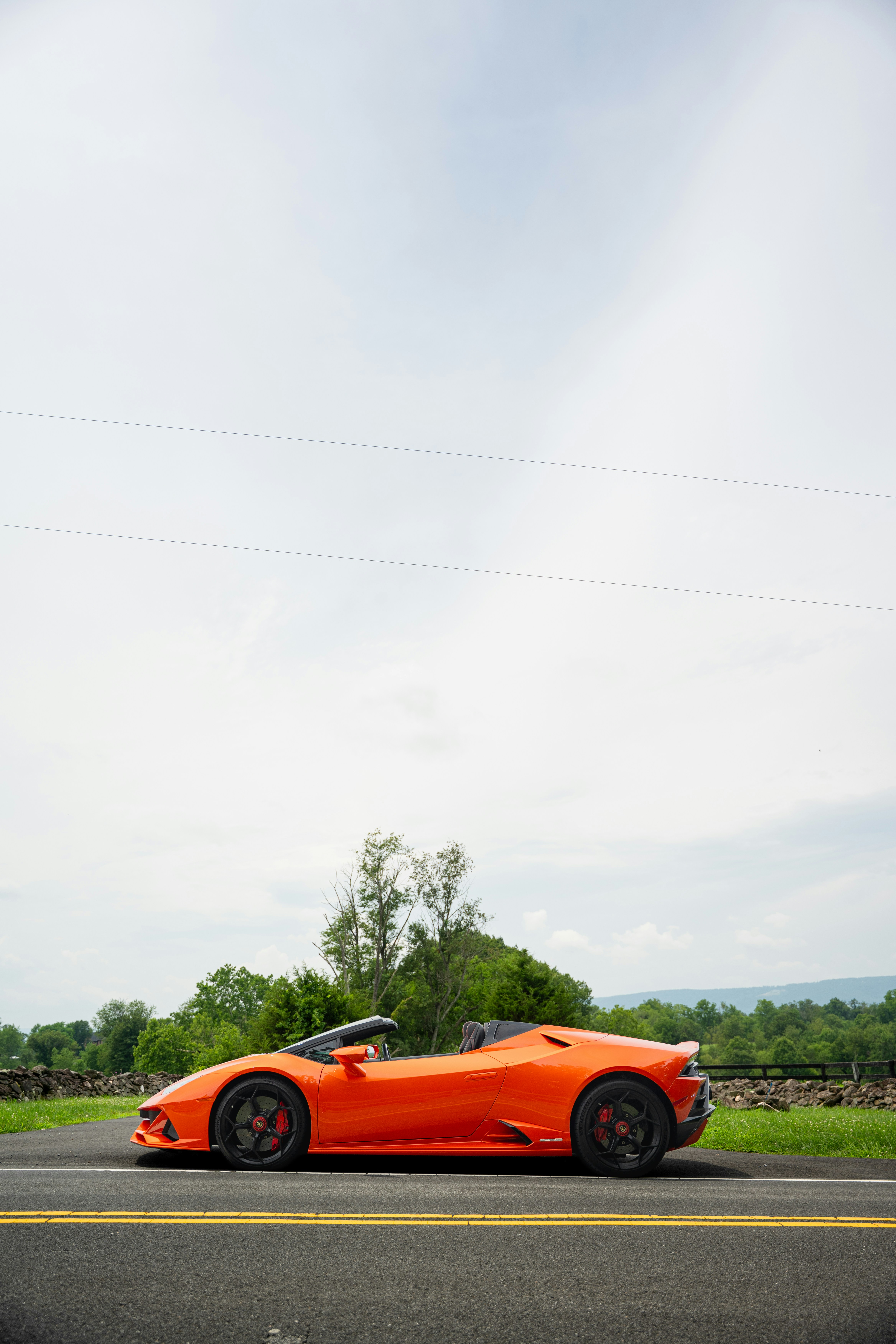 Orange Hypercar Resting on a Quiet Open Road
