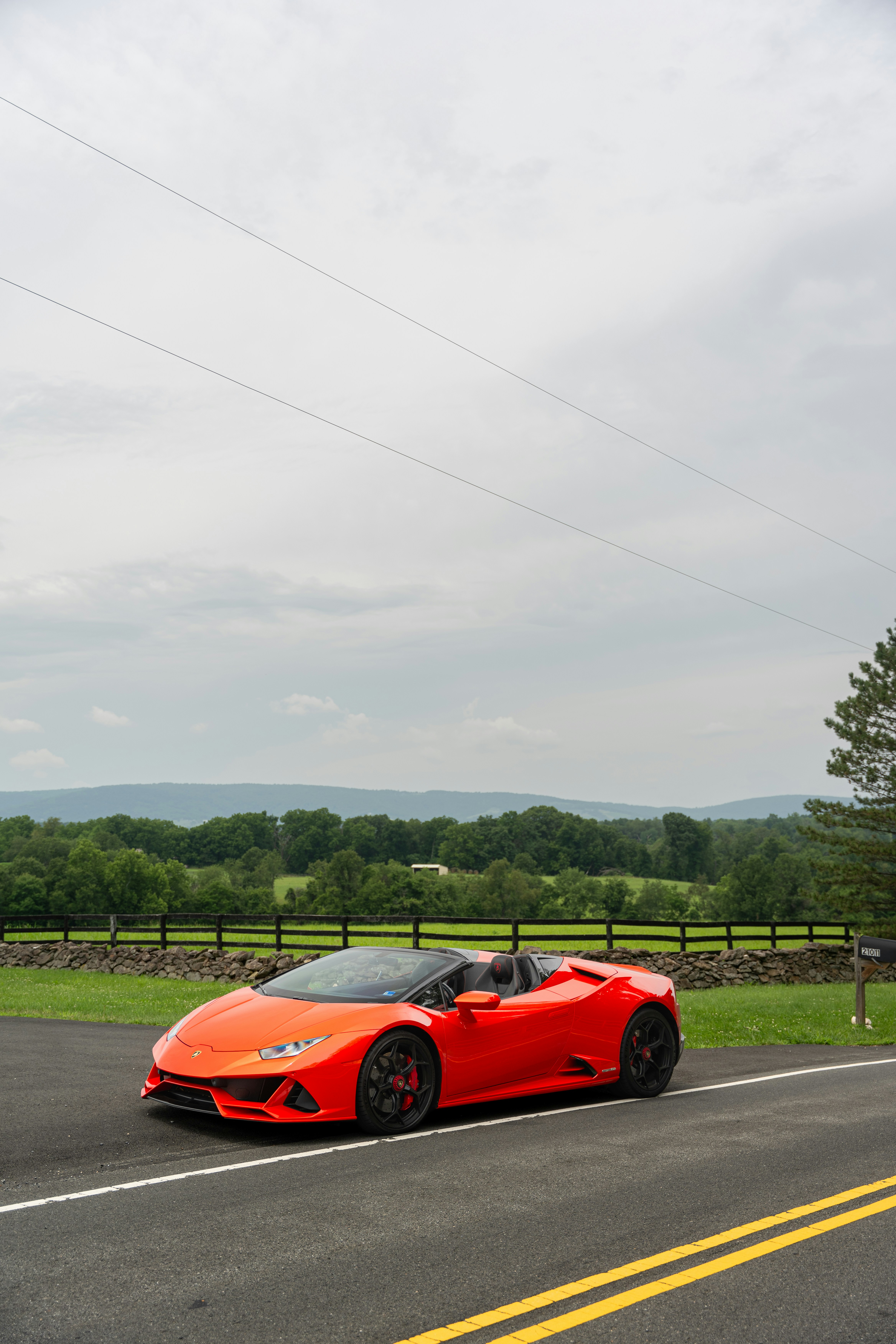 Red Exotic on Rural Ribbon: A Sunset-tinged Roadside Portrait