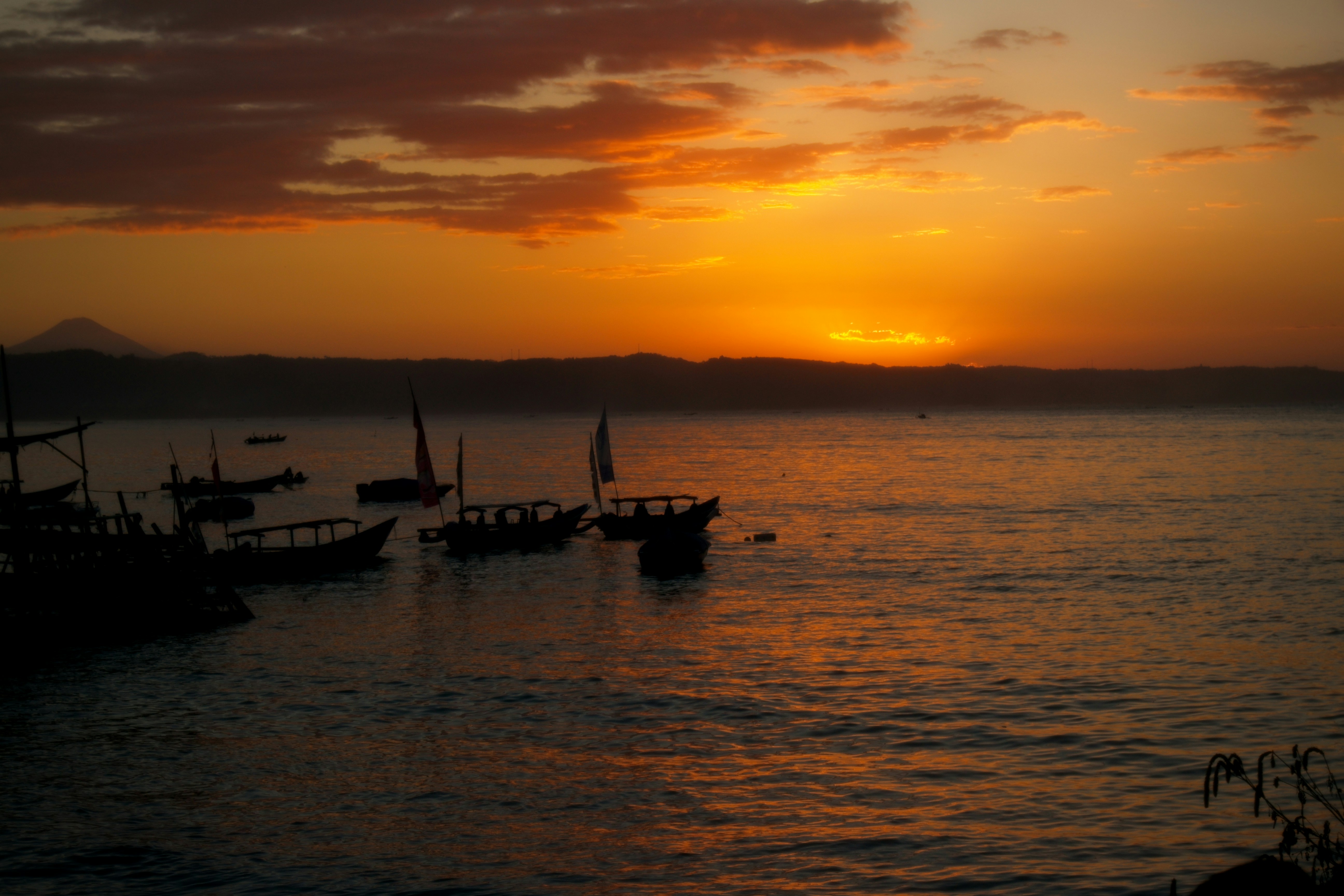 Horizon Fire: Boats at Dusk on a Calm Sea