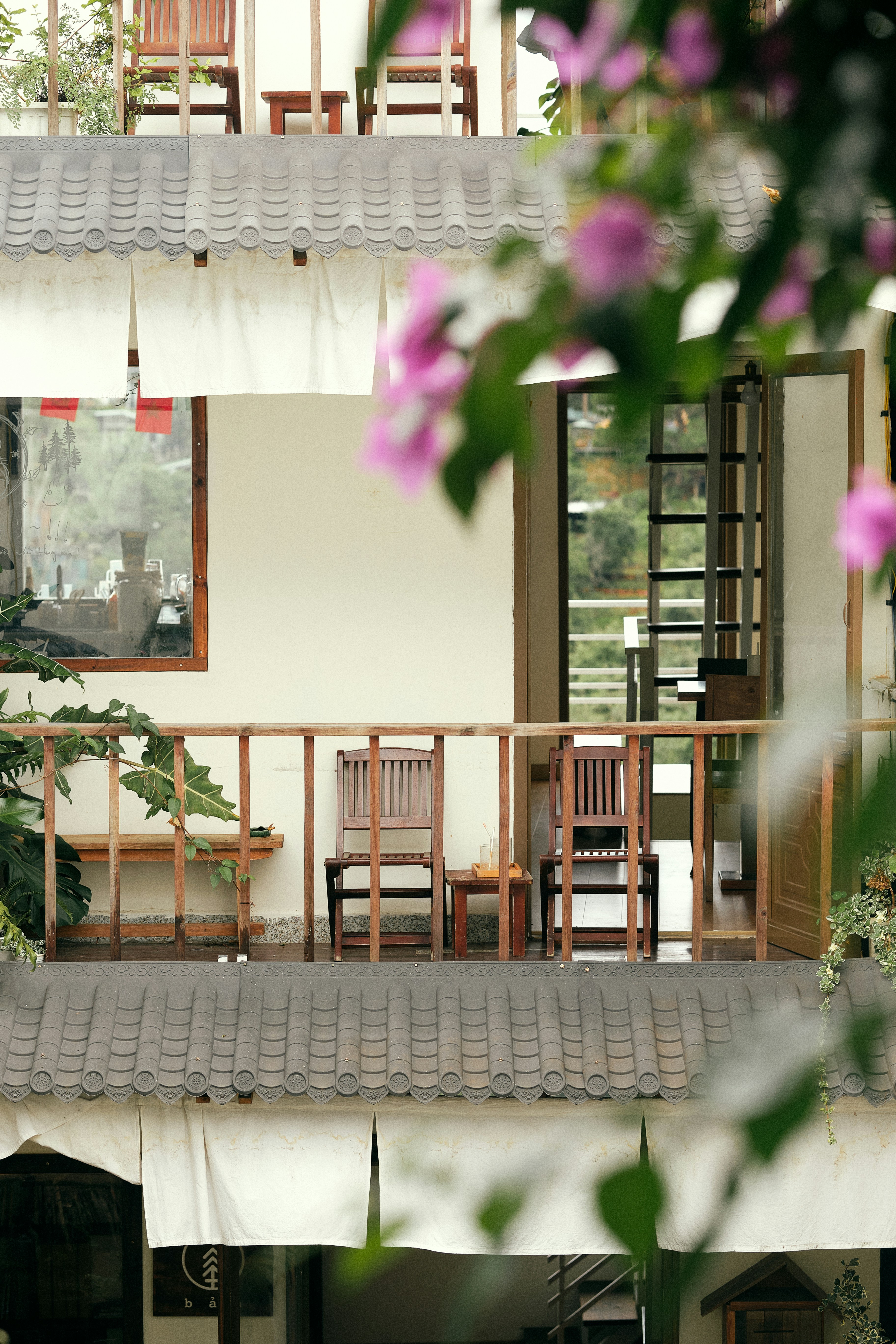 Quiet Balcony Café: Wooden Chairs Beneath a Protective Canopy