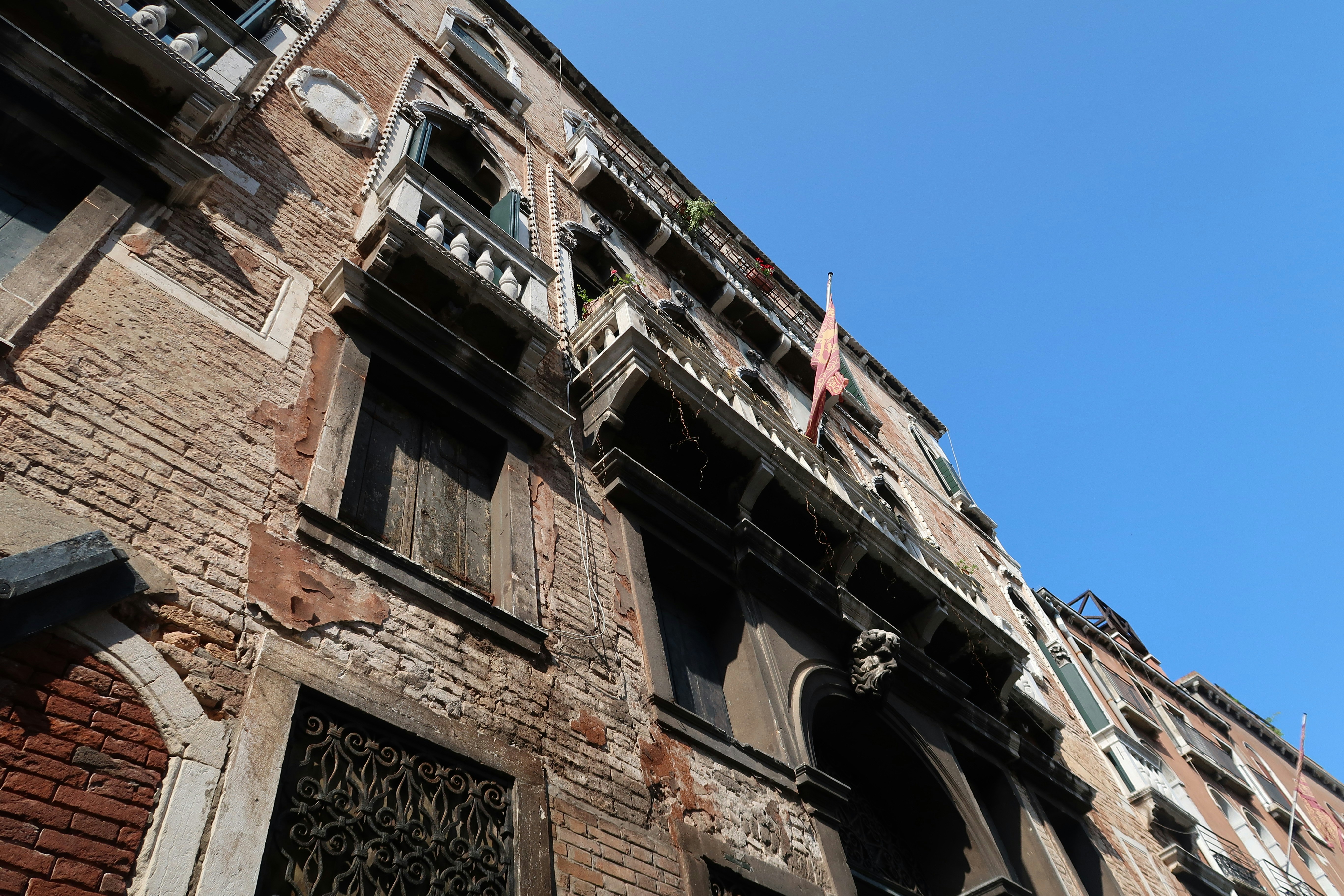 Brick Facade Rising to the Sky: A Venetian-tinged Balcony Scene