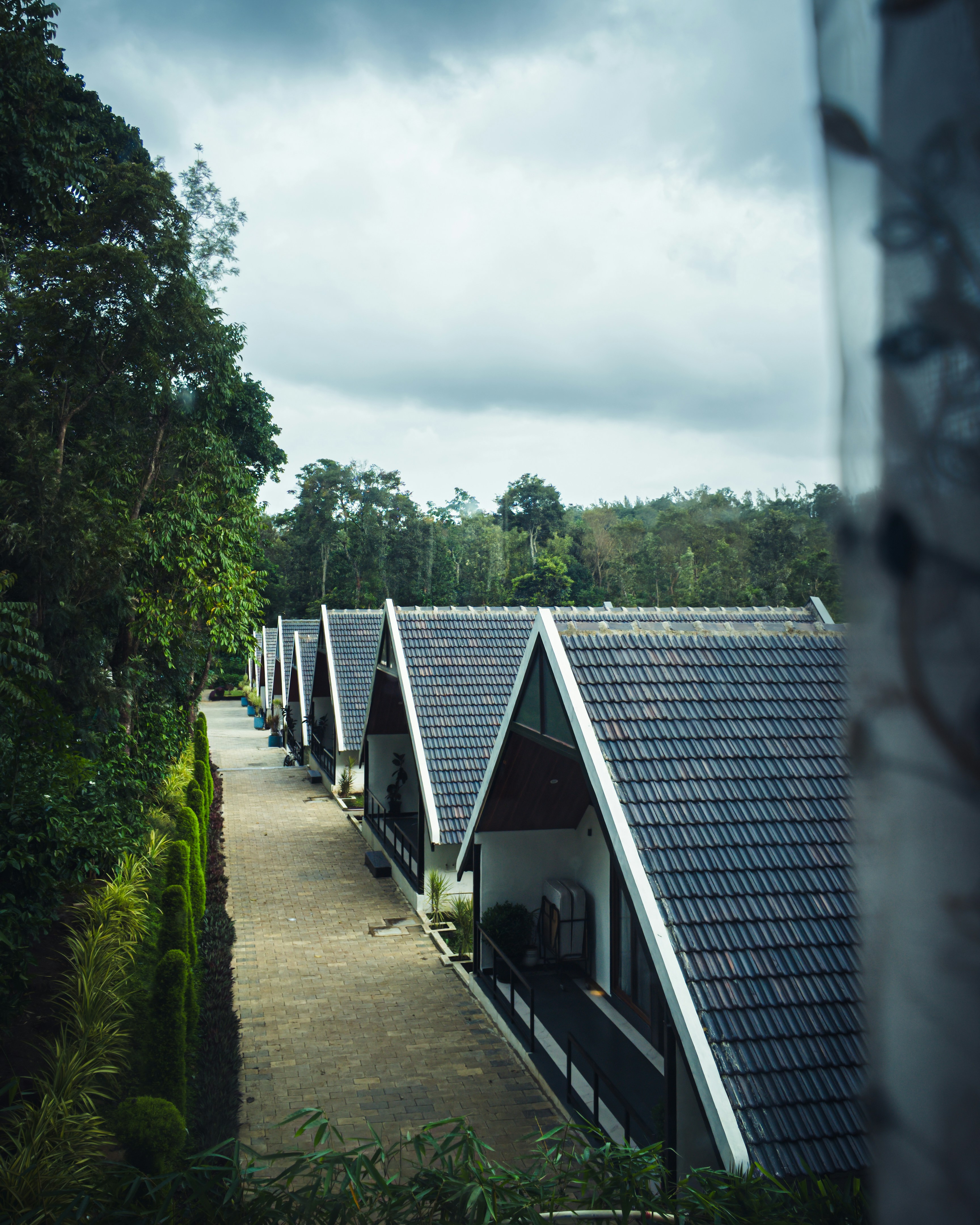 Row of A-Frame Houses Looming Along a Shaded Path