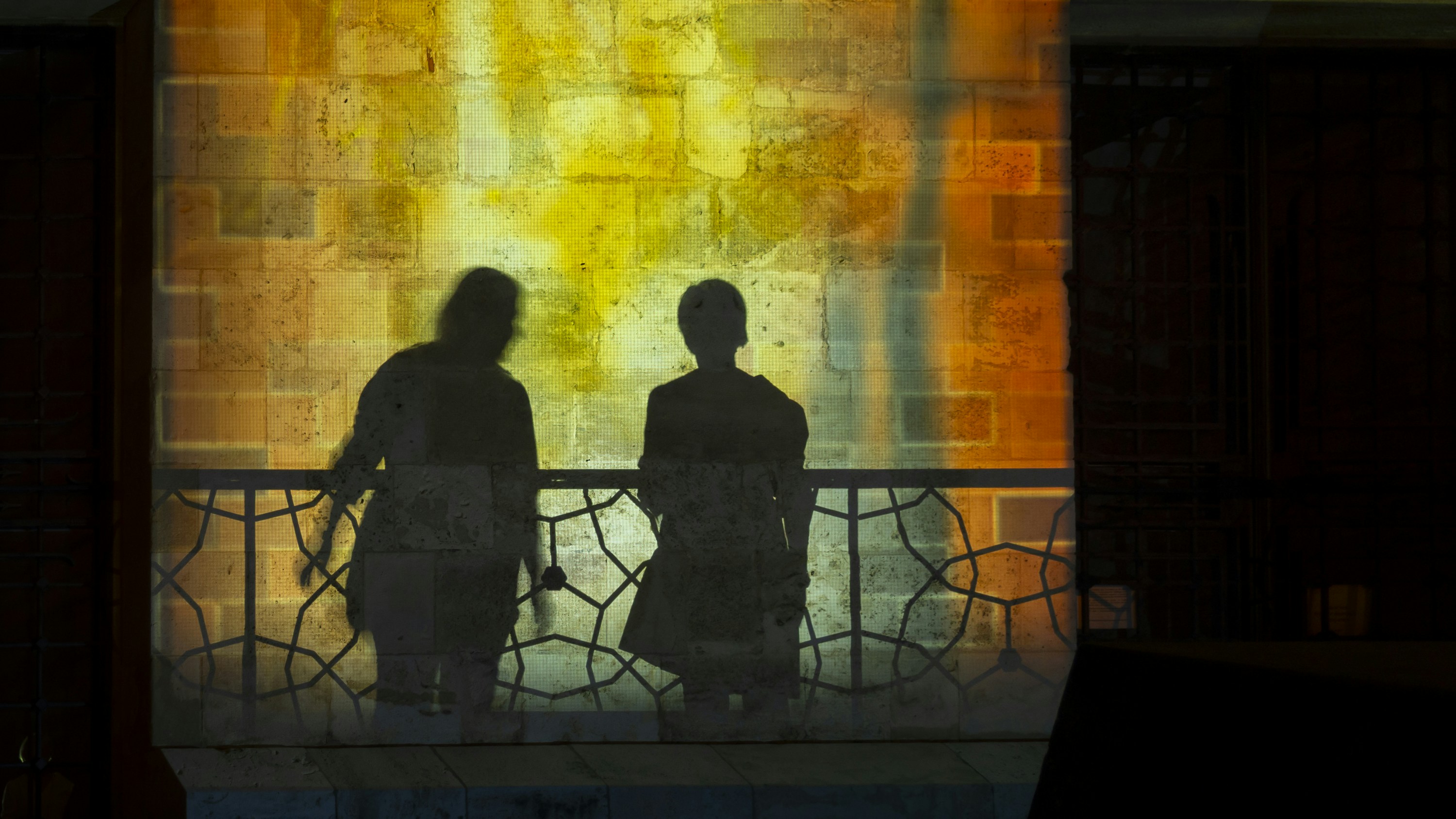 Silhouetted Figures on a Moonlit Balcony