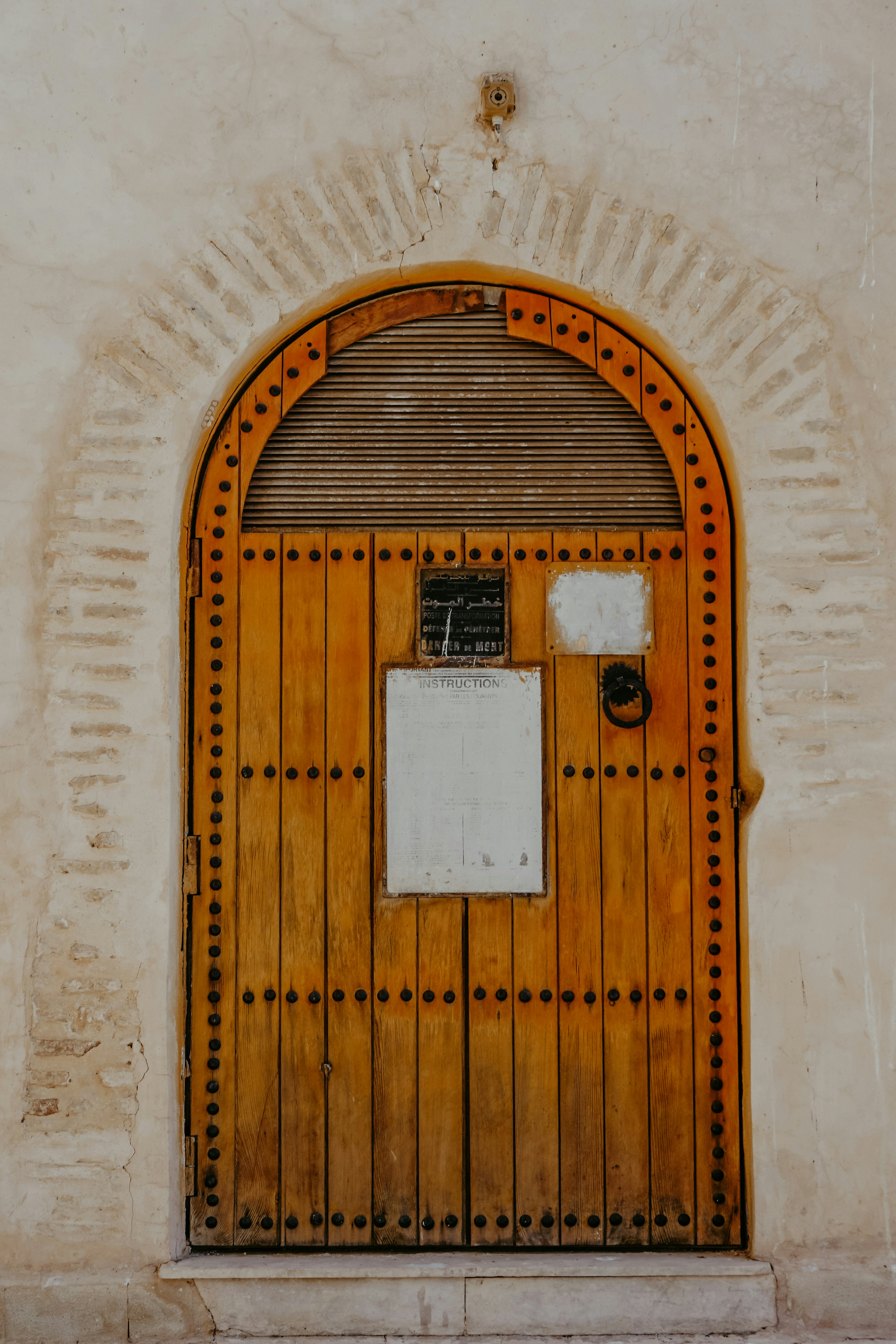 Ornate arched wooden door with metal studs.