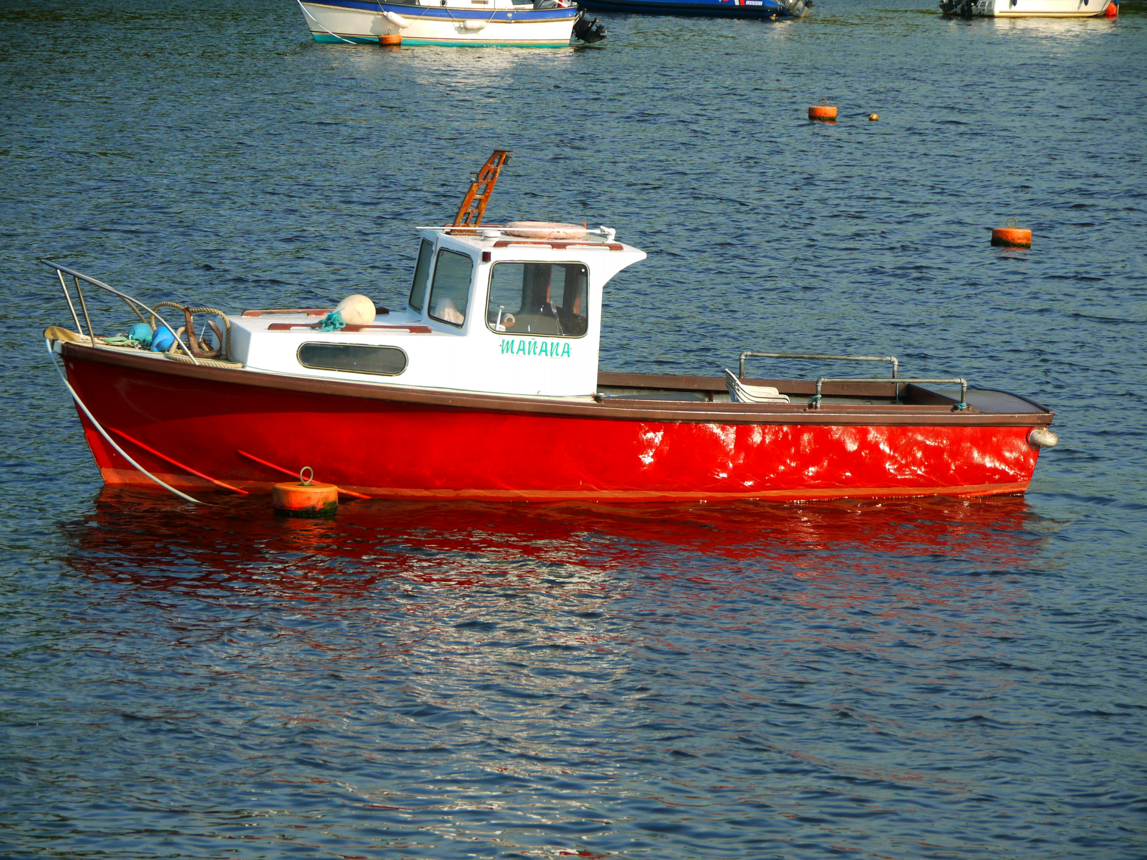 Red Workboat Anchored in Sunlit Harbor