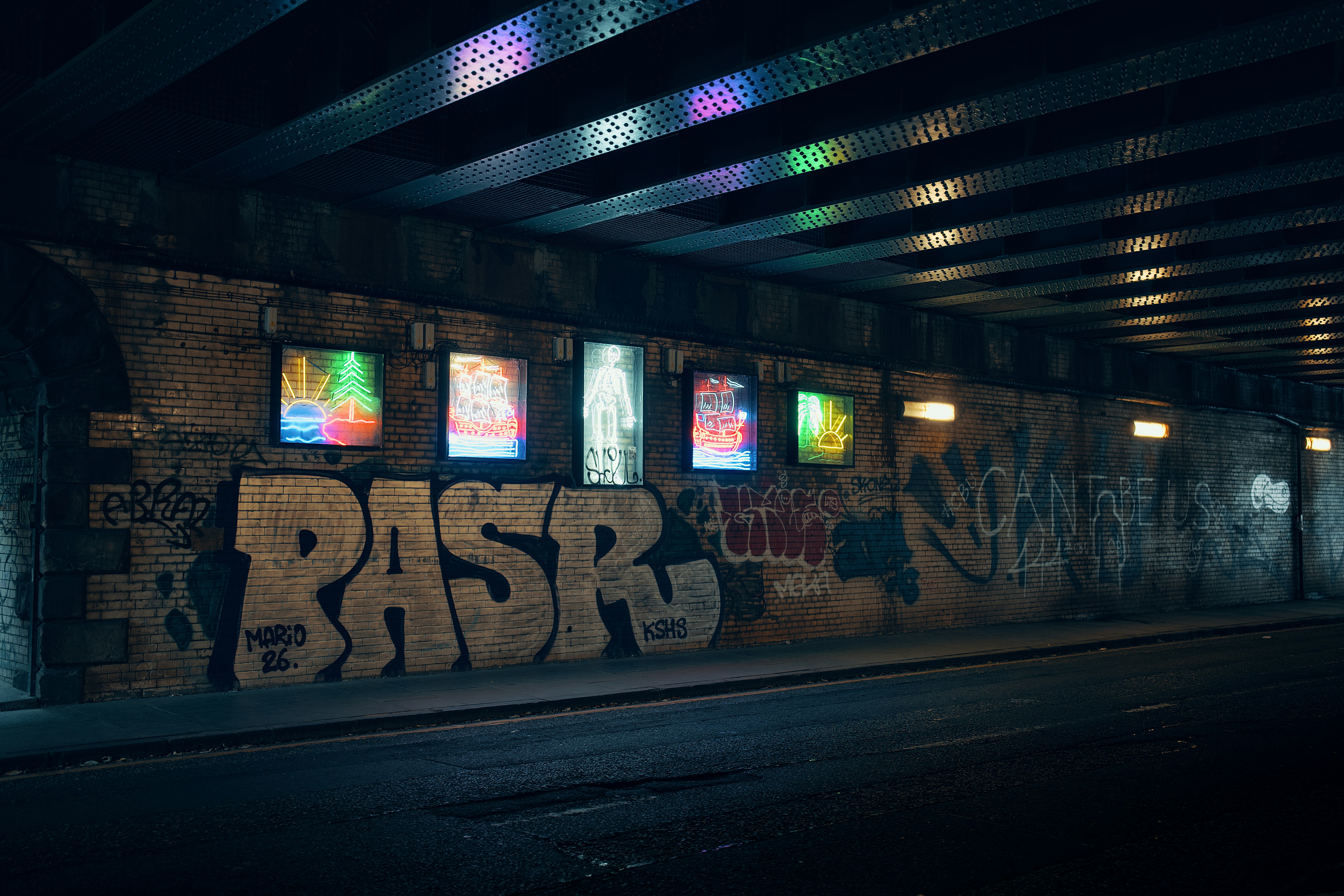 Neon Fragments on a Graffitied Tunnel Wall