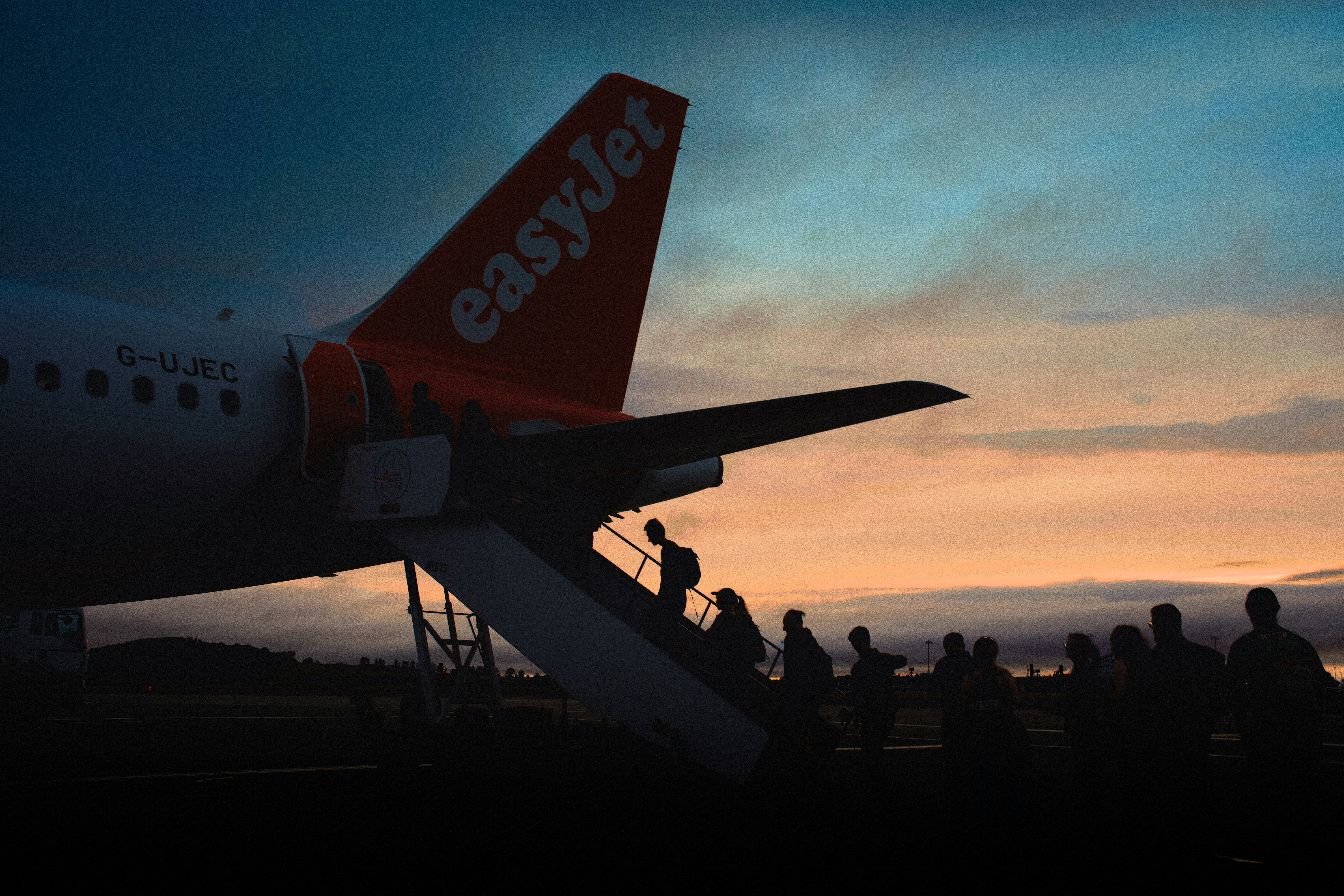 Sunset Gate: Passengers in Shadow as an EasyJet Jet Stands Ready for Departure