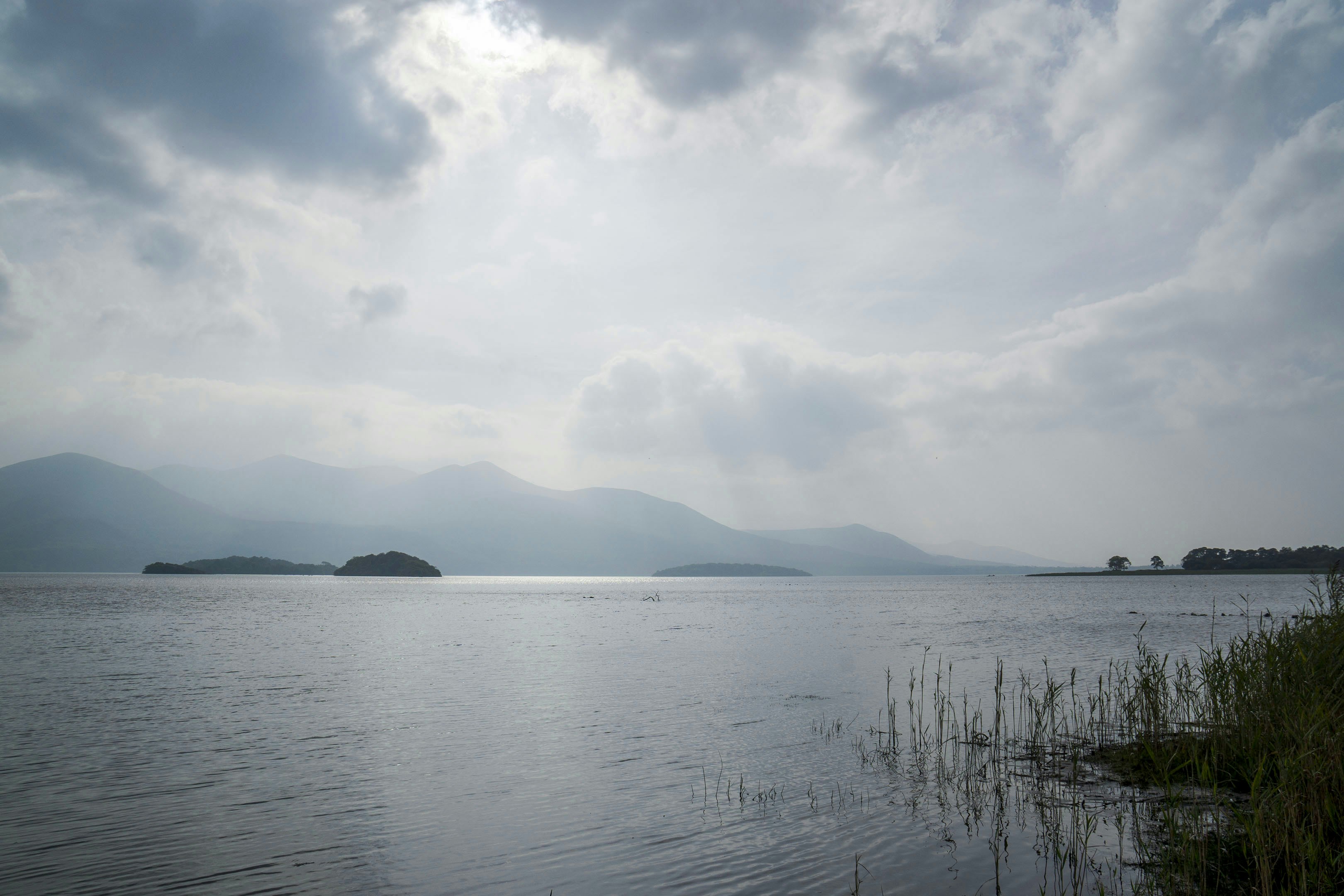 Silenced Sea Lights: Distant Peaks Beneath Quiet Clouds
