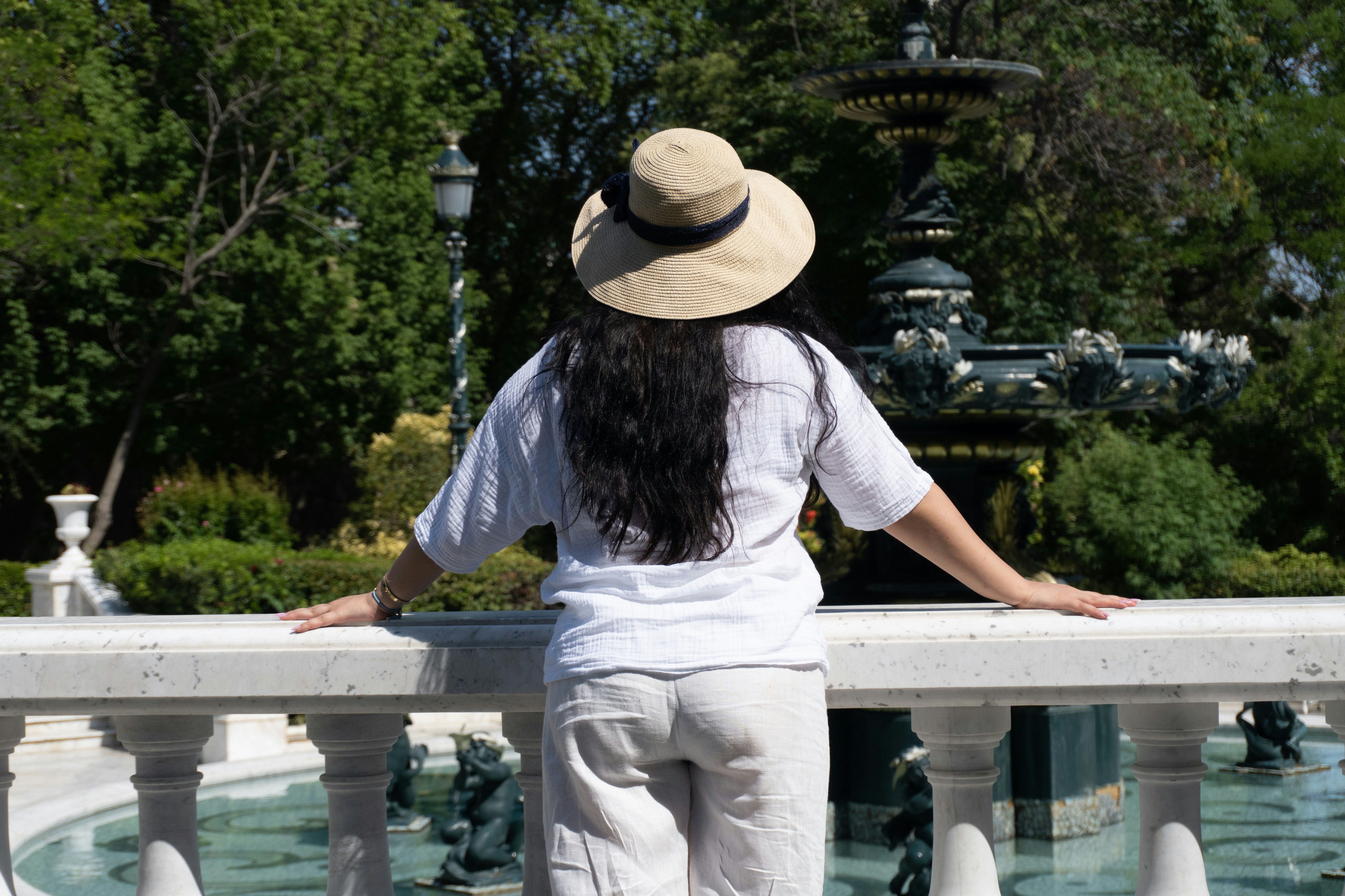 Hat, White Shirt, and a Distant Fountain: A Portrait from the Balcony