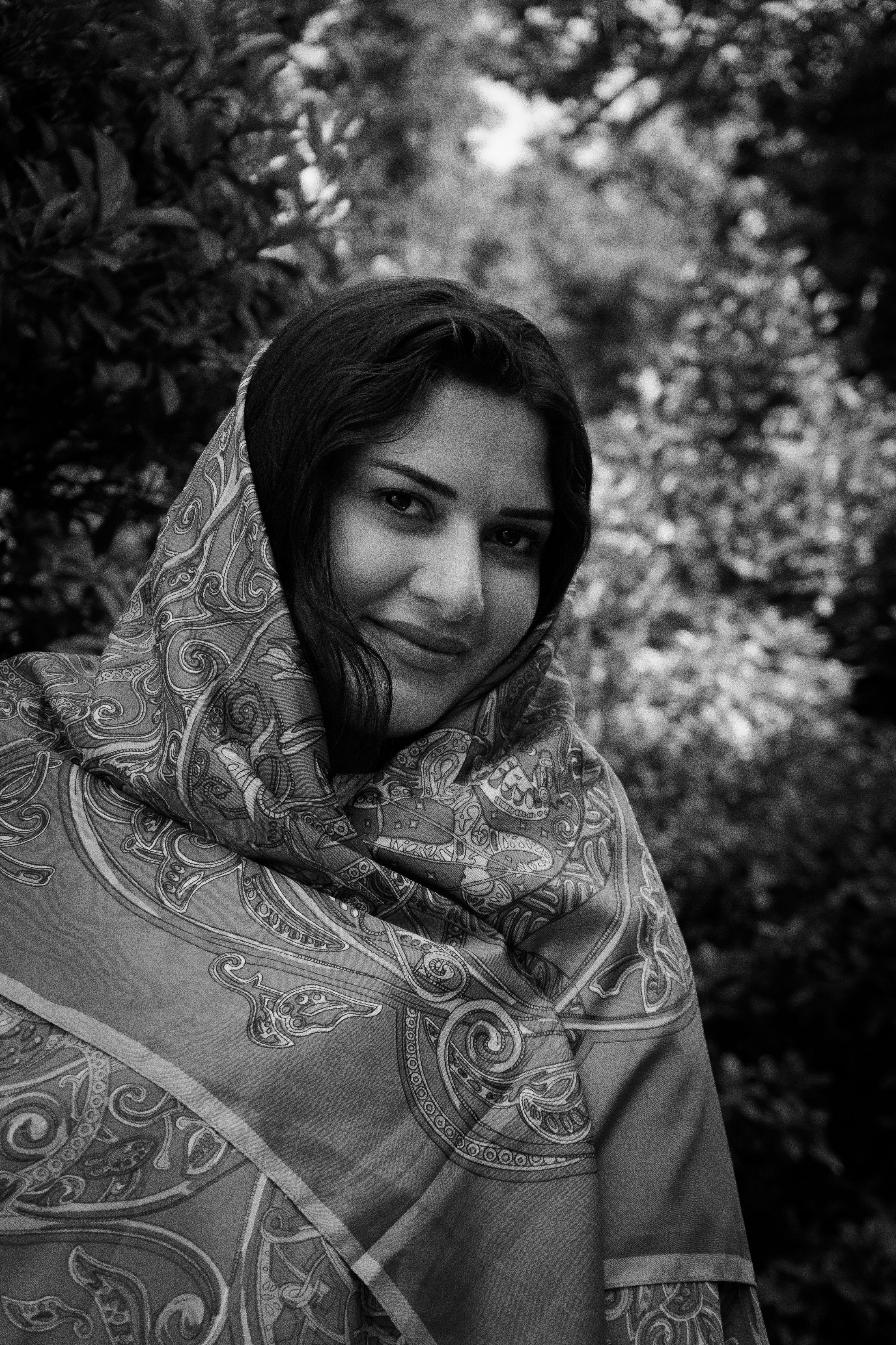 Veiled smile beneath patterned shawl