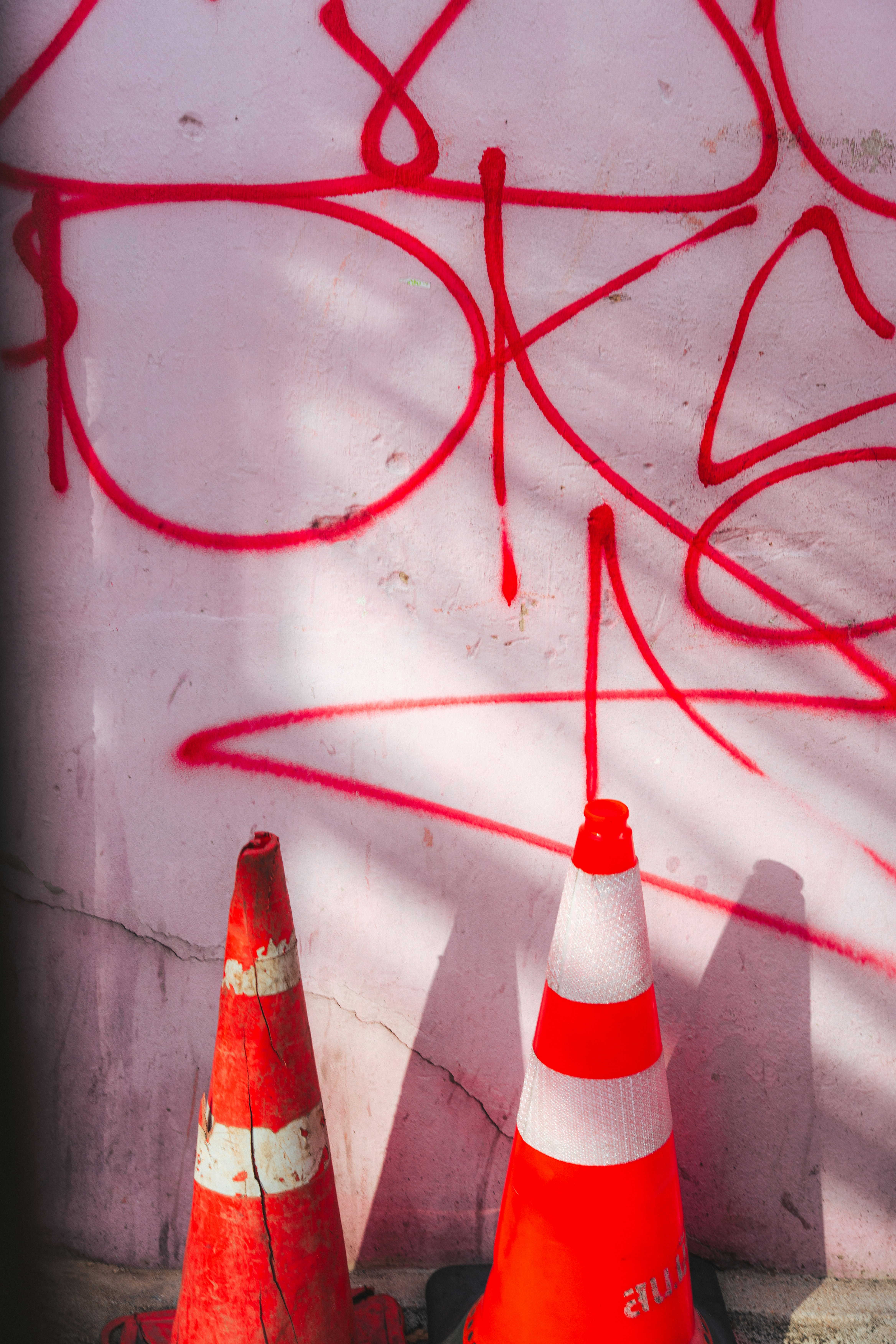 Bright Red Cones Stand Against Crimson Graffiti