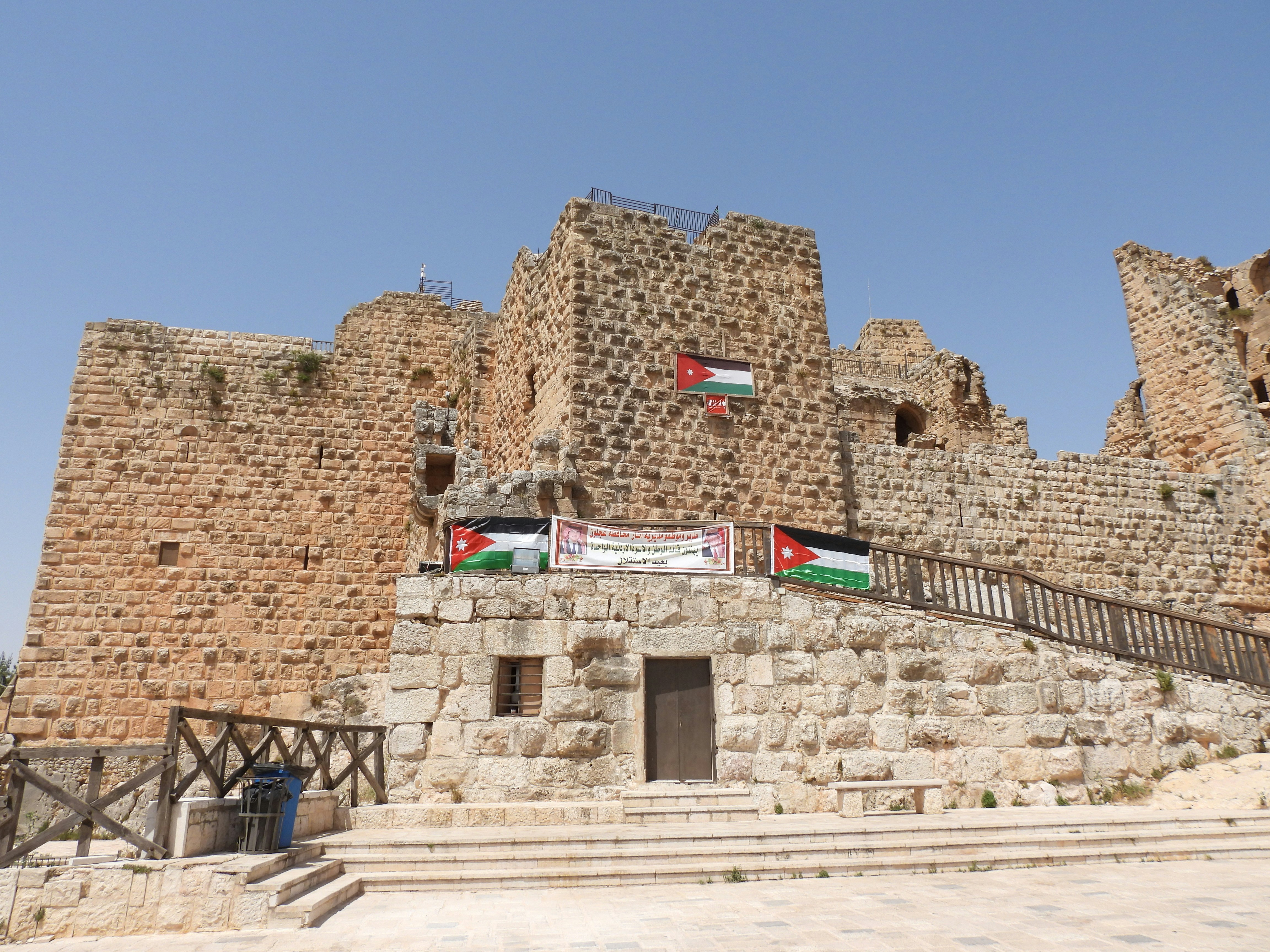 Stone Fortresses and Flags: A Sunlit Citadel Clad in Flags