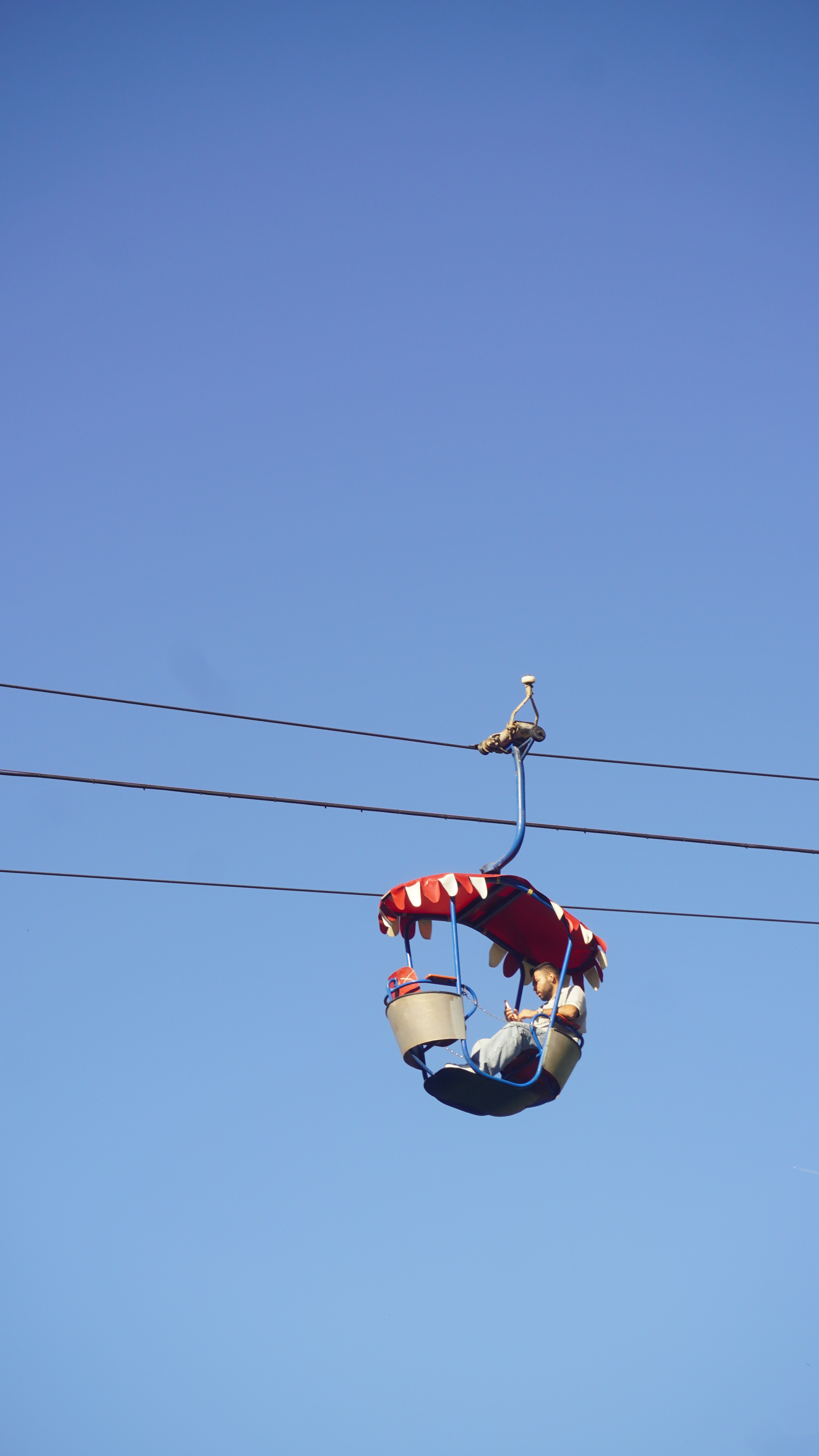 Skyride Silhouette: A Child’s Basket of Light on a Clear Blue Afternoon