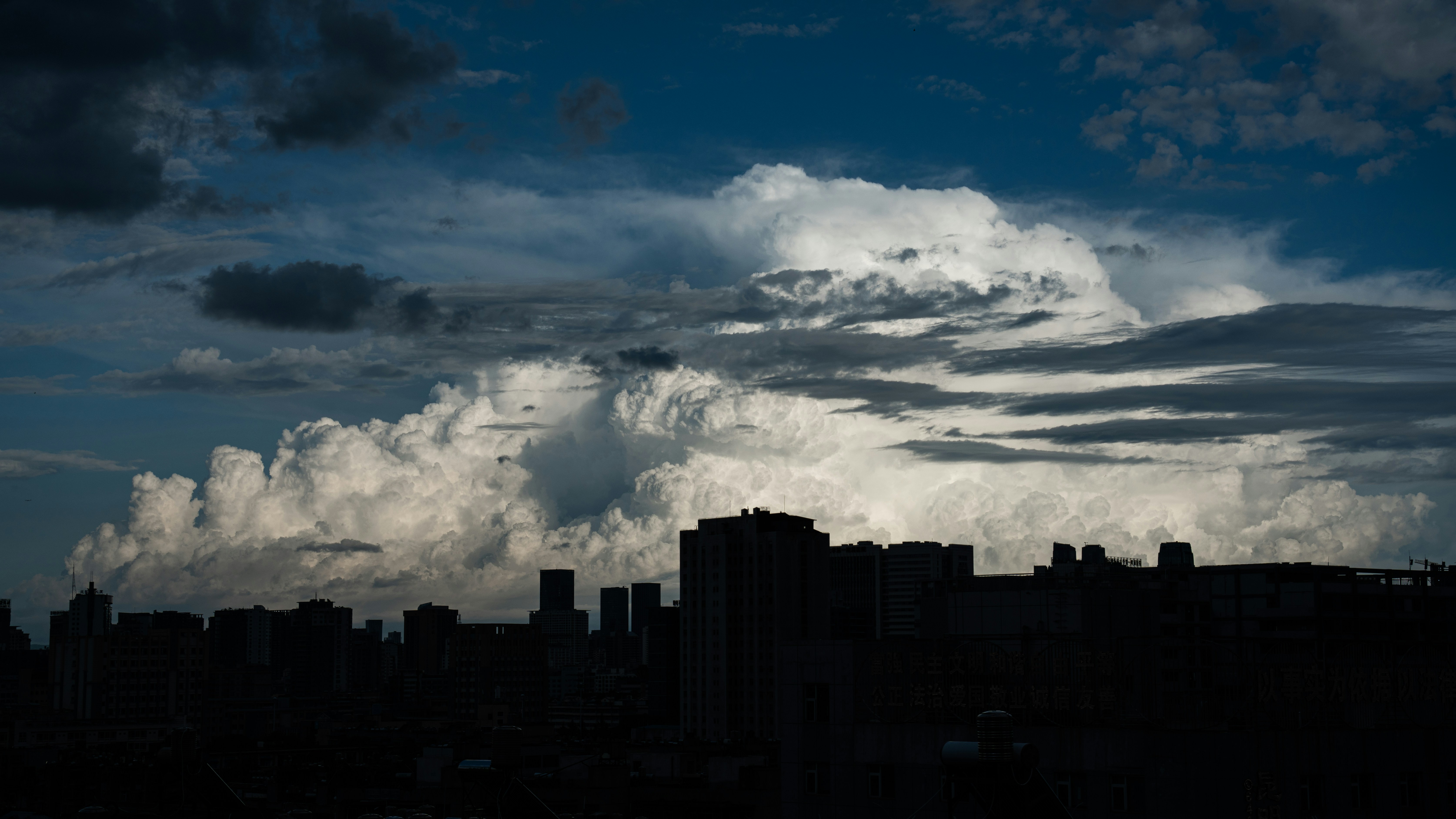 Silhouette Skyline Beneath a Radiant Cloud Break