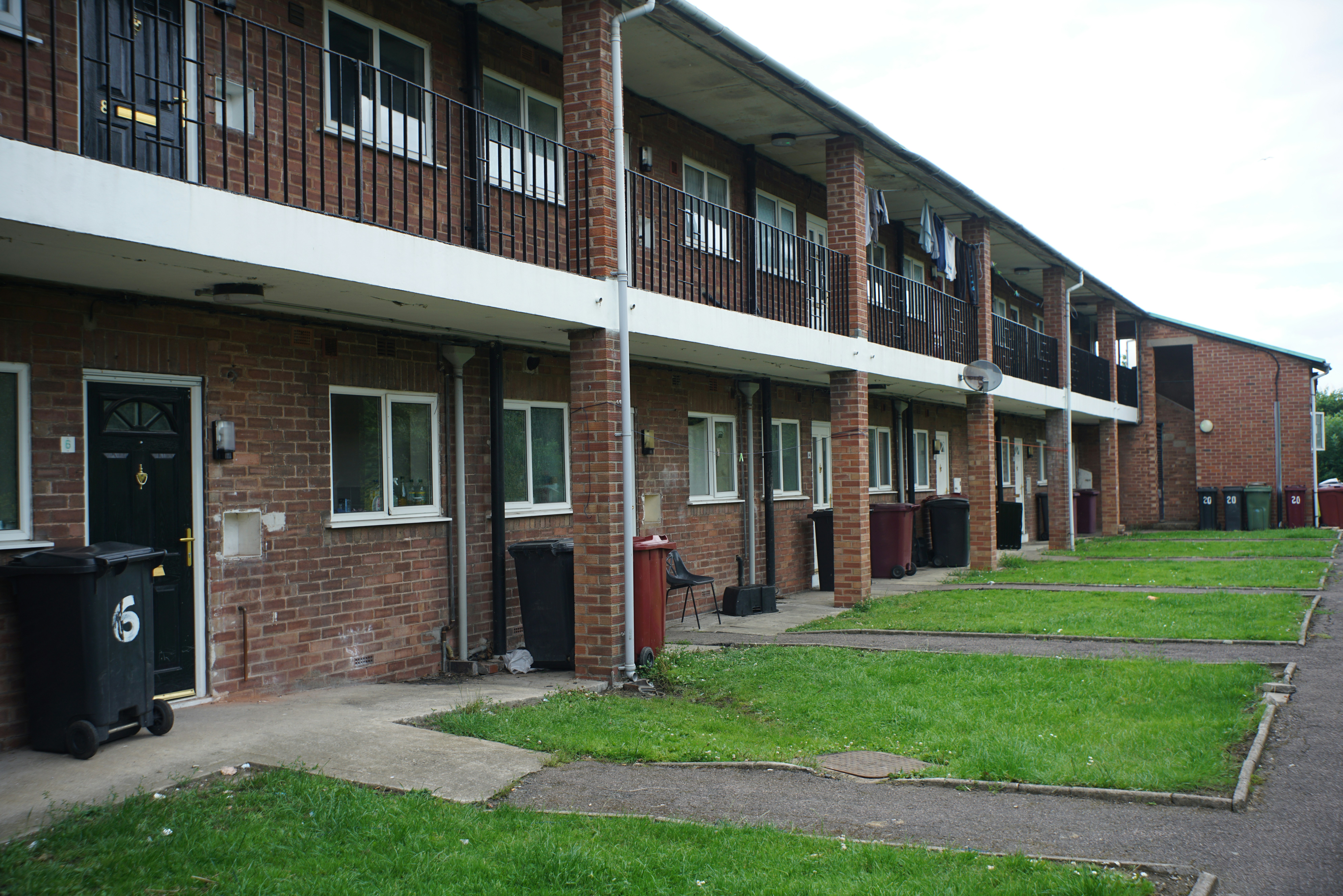 Row of brick apartments under a shaded balcony