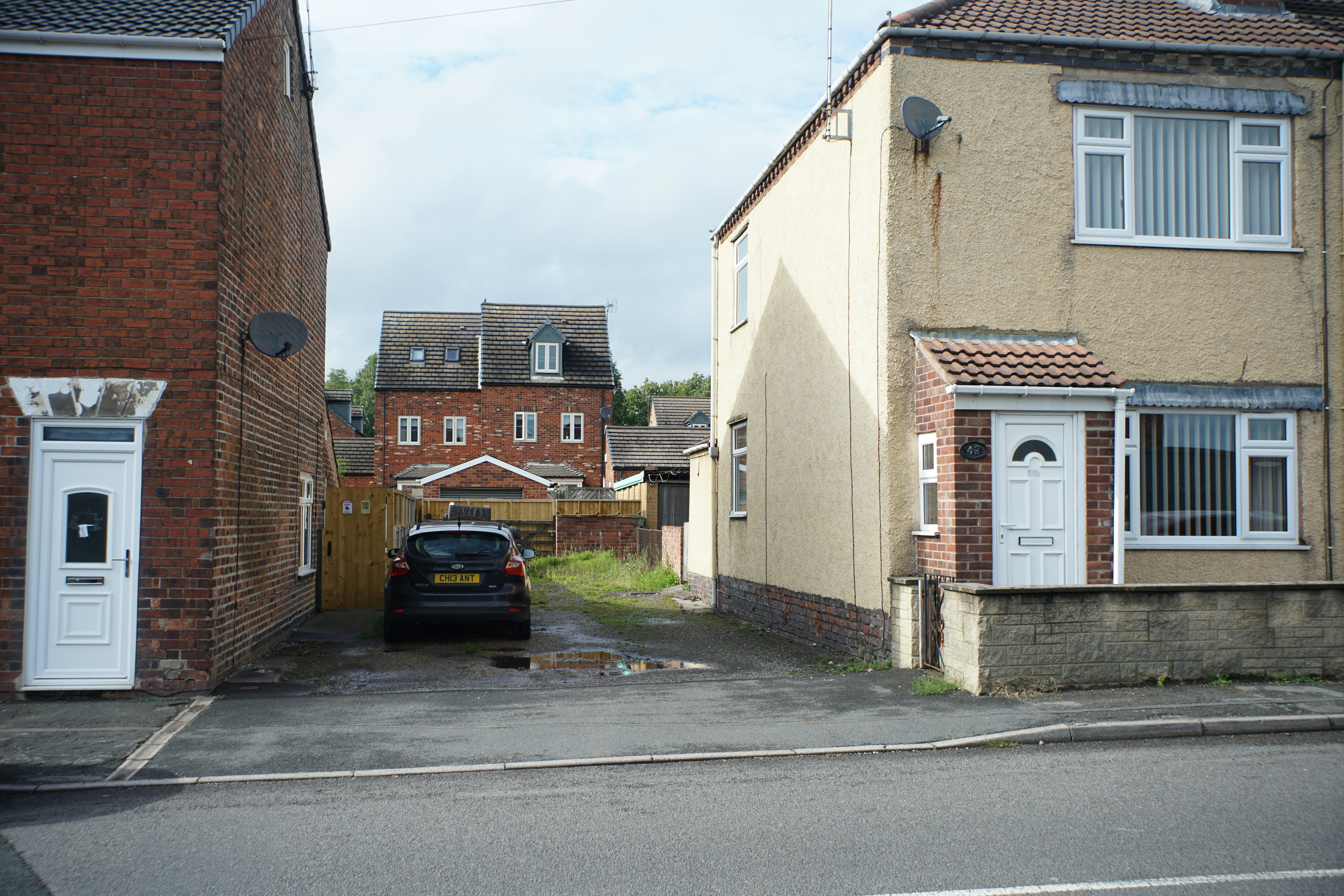 Between Two Driveways: A Quiet Street Leading to a Red Brick House Row