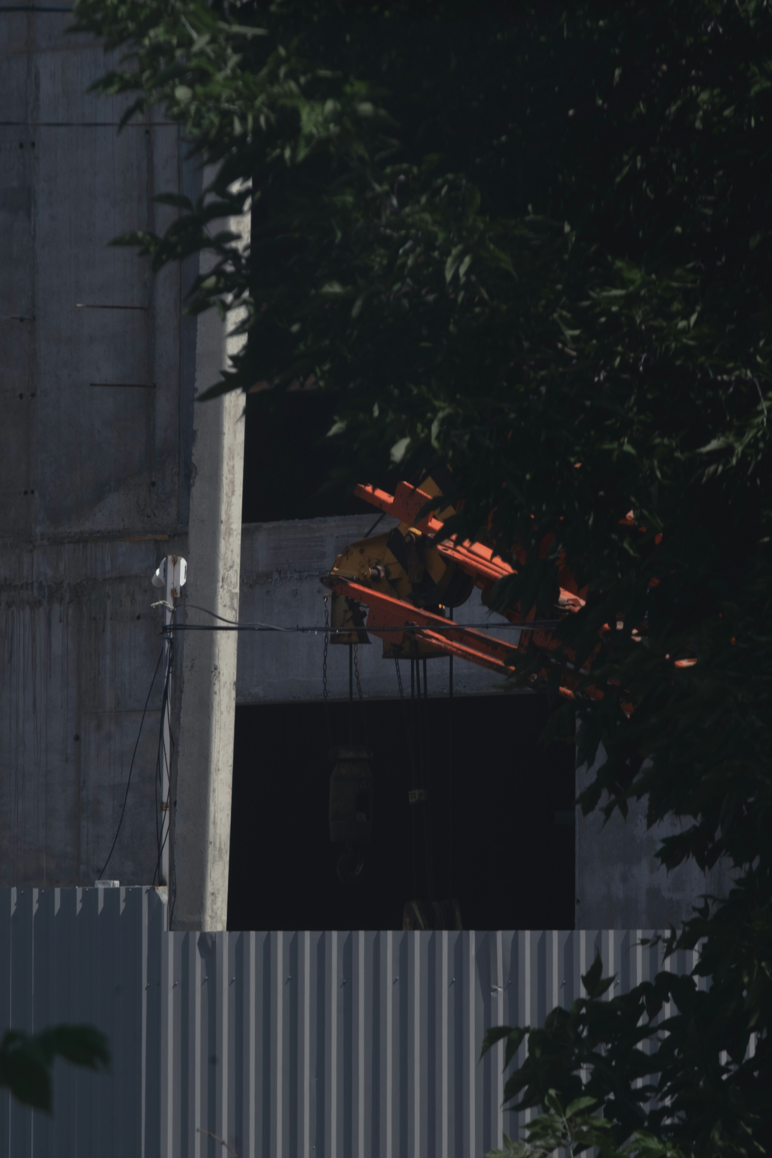 Hidden Crane Overhang: Concrete Frame with Red Shingles Peeking Through
