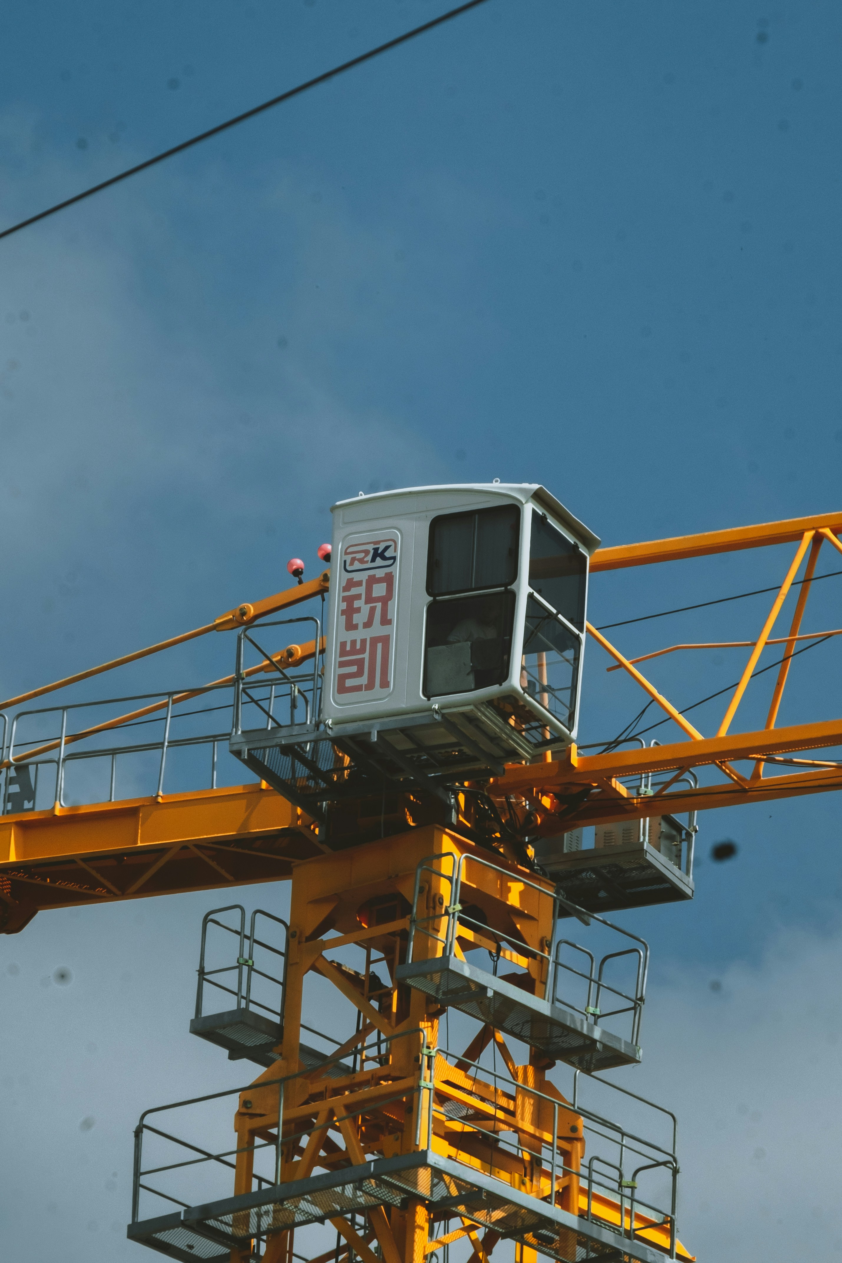 Orange Crane Tower Reaches Skyward Under Clear Blue