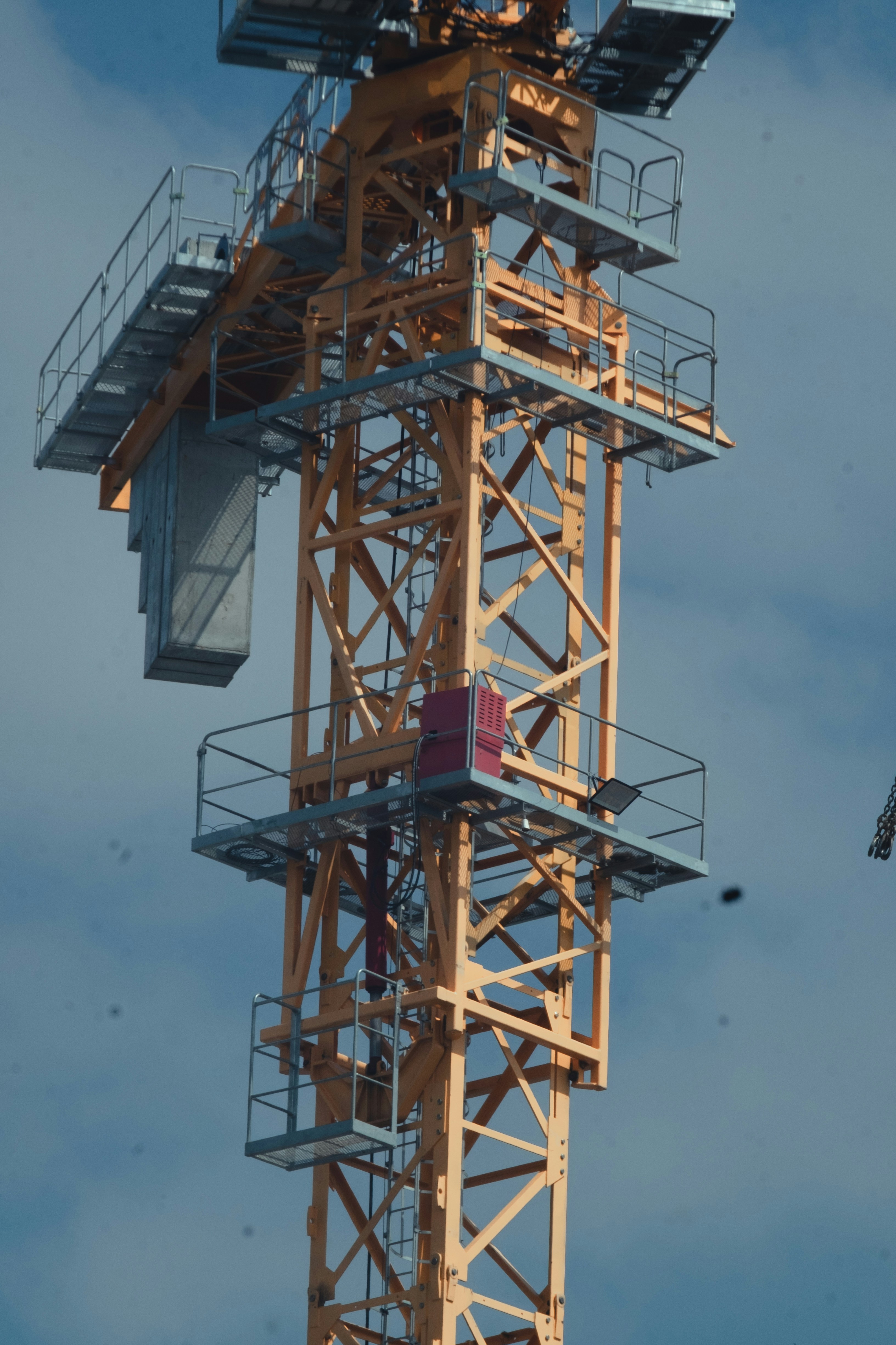 Towering Crane Aerial: Orange Framework Against a Clear Sky
