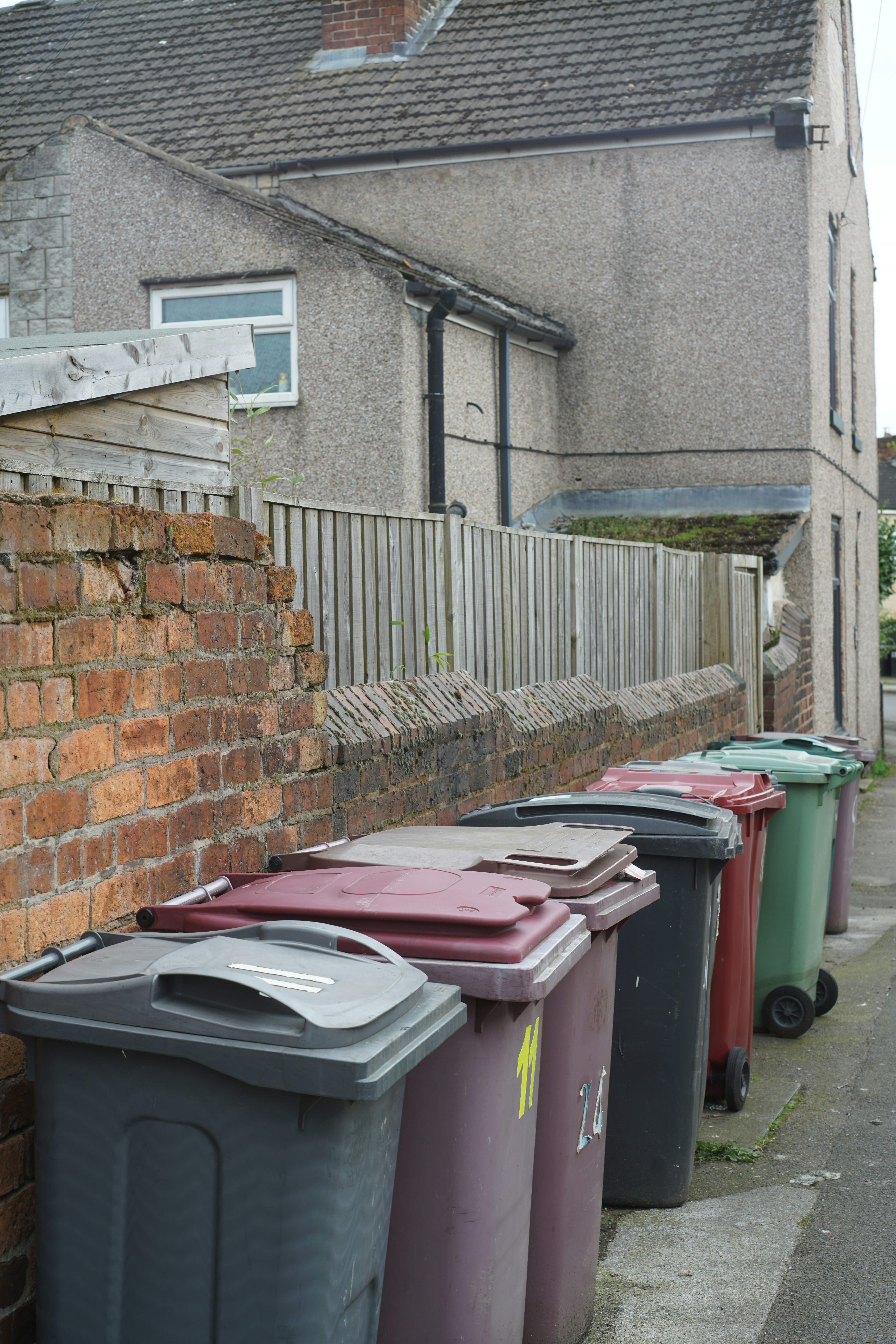 Rows of Colorful Bins Guard a Quiet Residential Alley