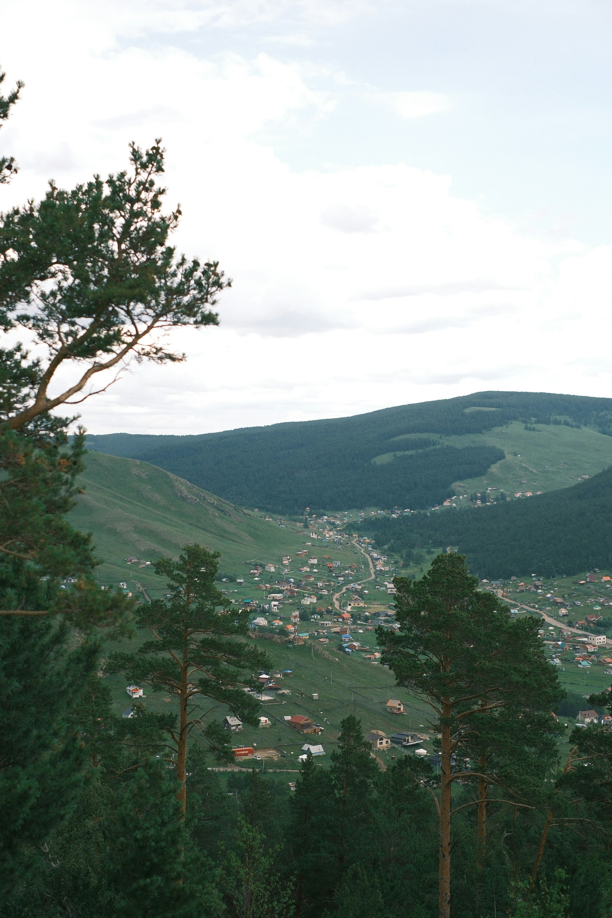 Villages Snaking Through Green Valleys beneath Cloudy Sky