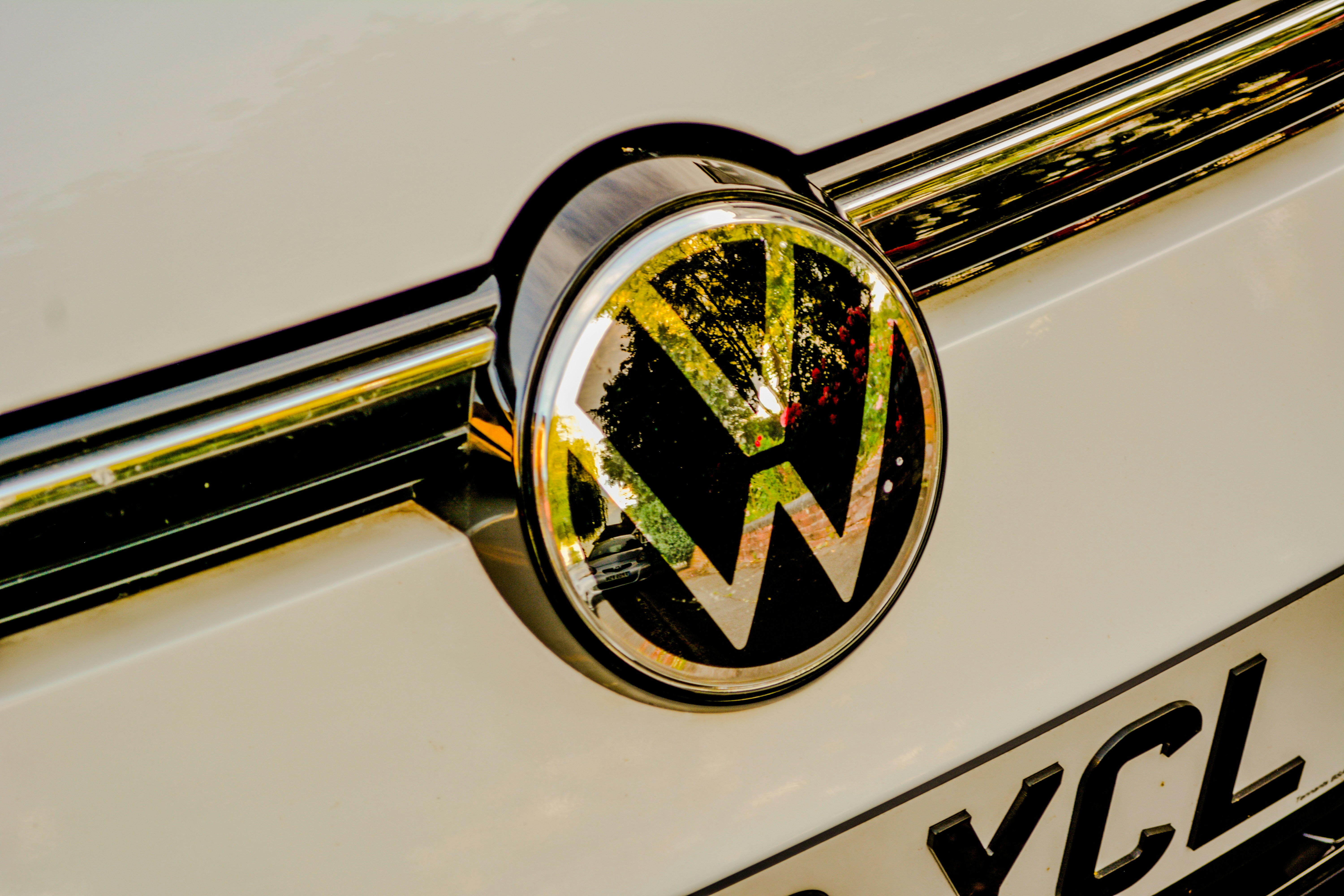 Emblem in Focus: A Volkswagen Badge Framed by Chrome and Cream Paint