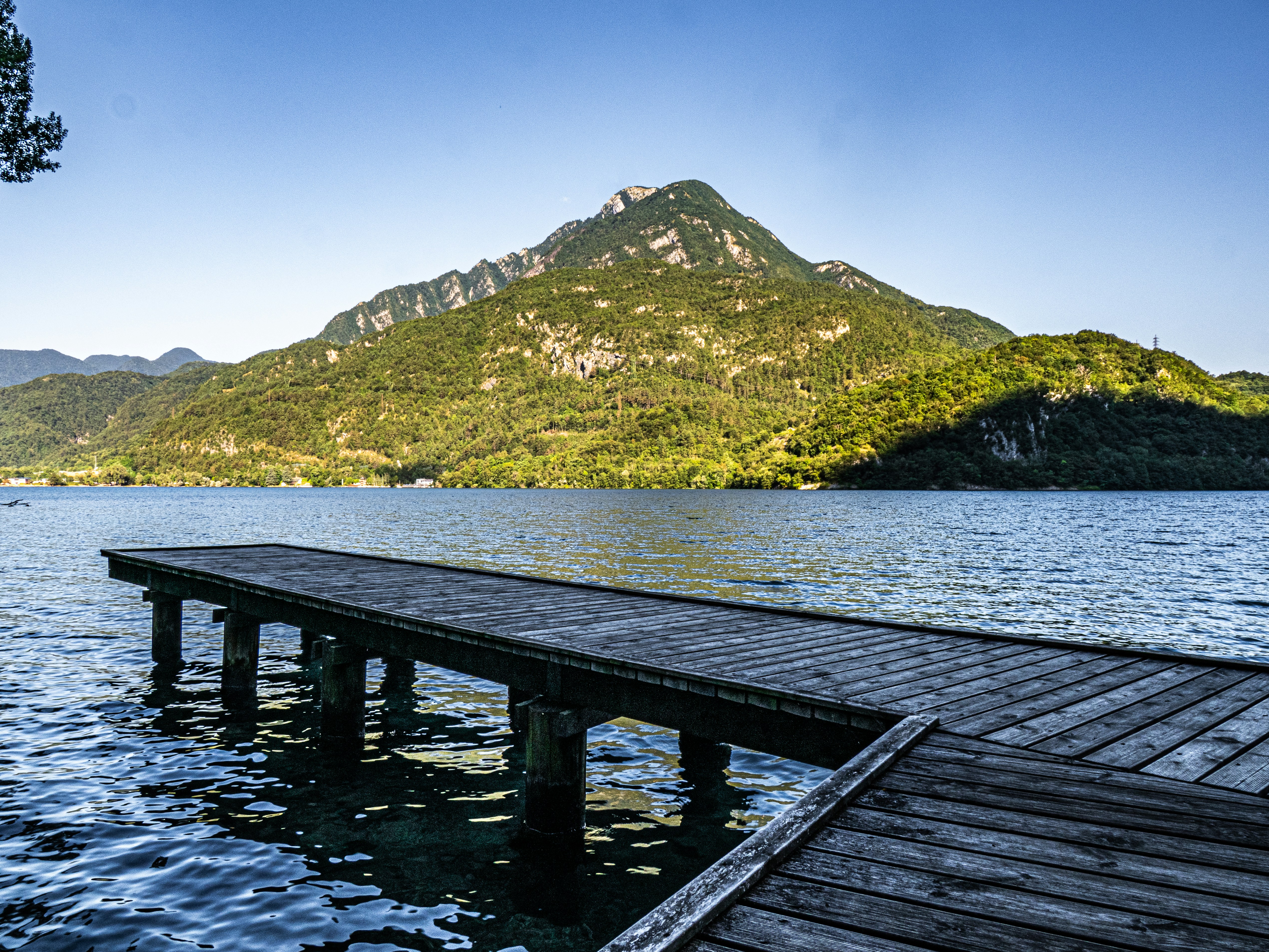 Wooden Pier Reaches Toward a Verdant Mountain Lake