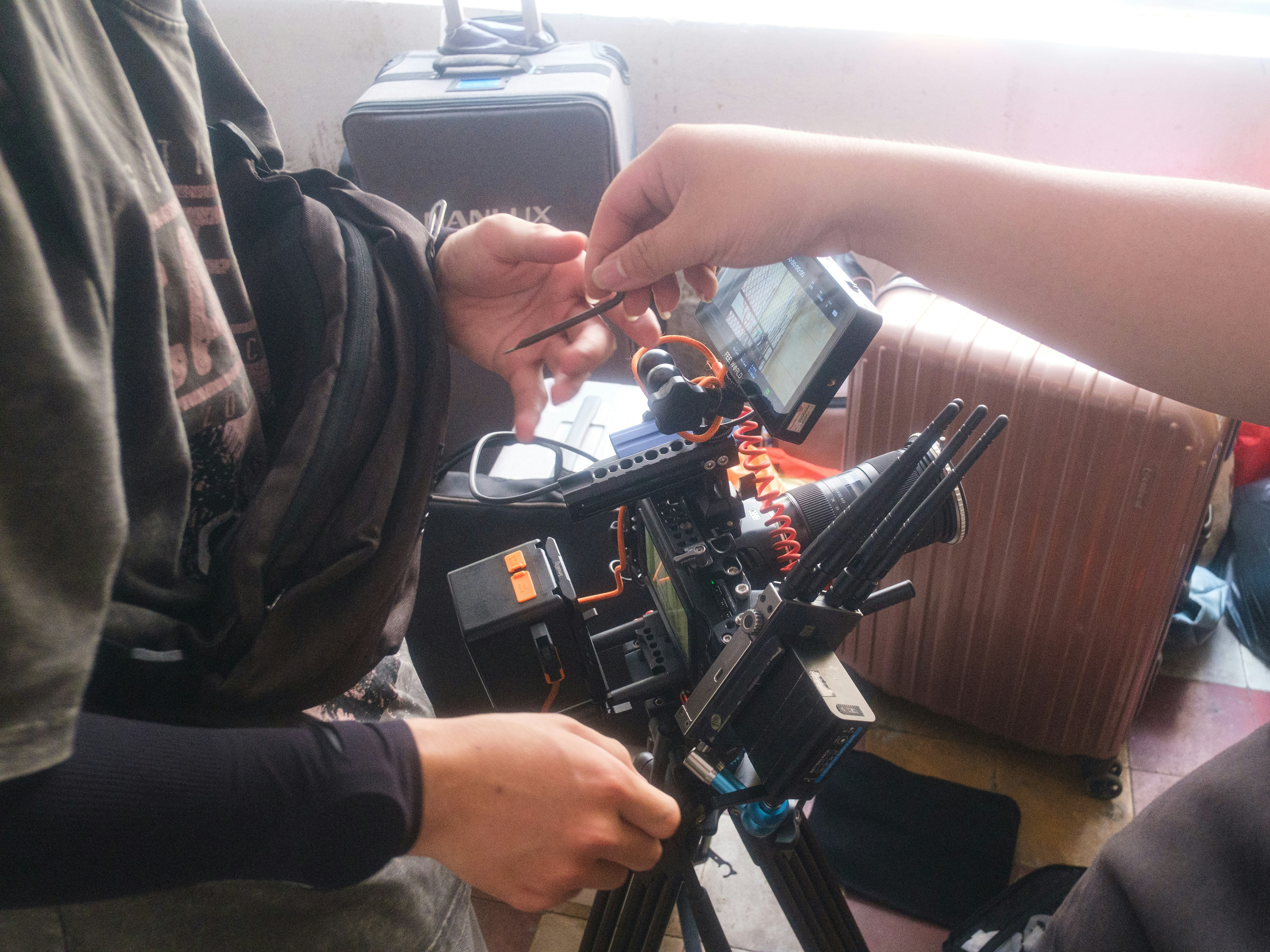 Close-up of a handheld camera rig under assembly on a soft seat