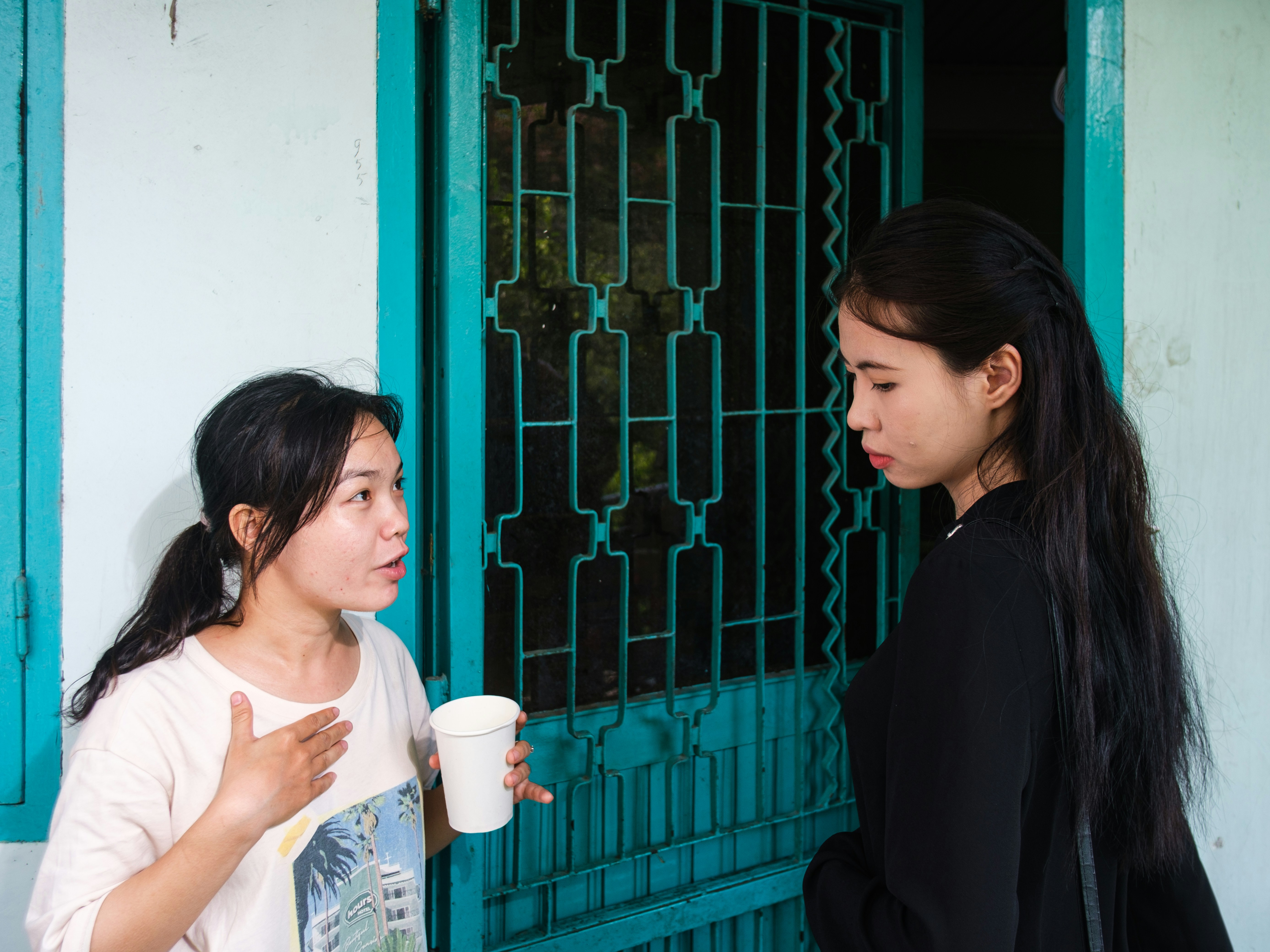 Conversational Exchange at a Teal Doorway