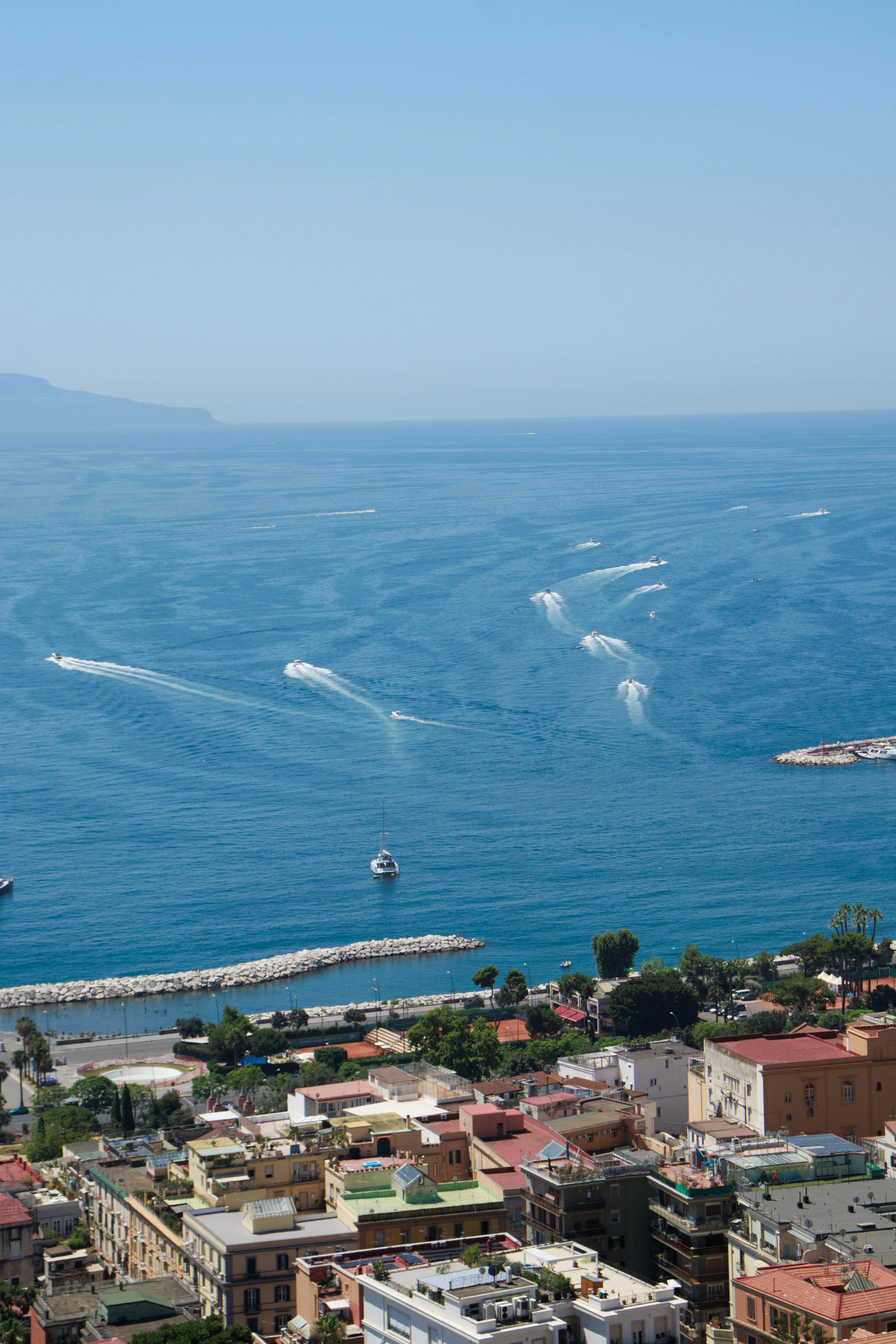 Coastal Town as Boats Carve White Trails Across a Cerulean Sea