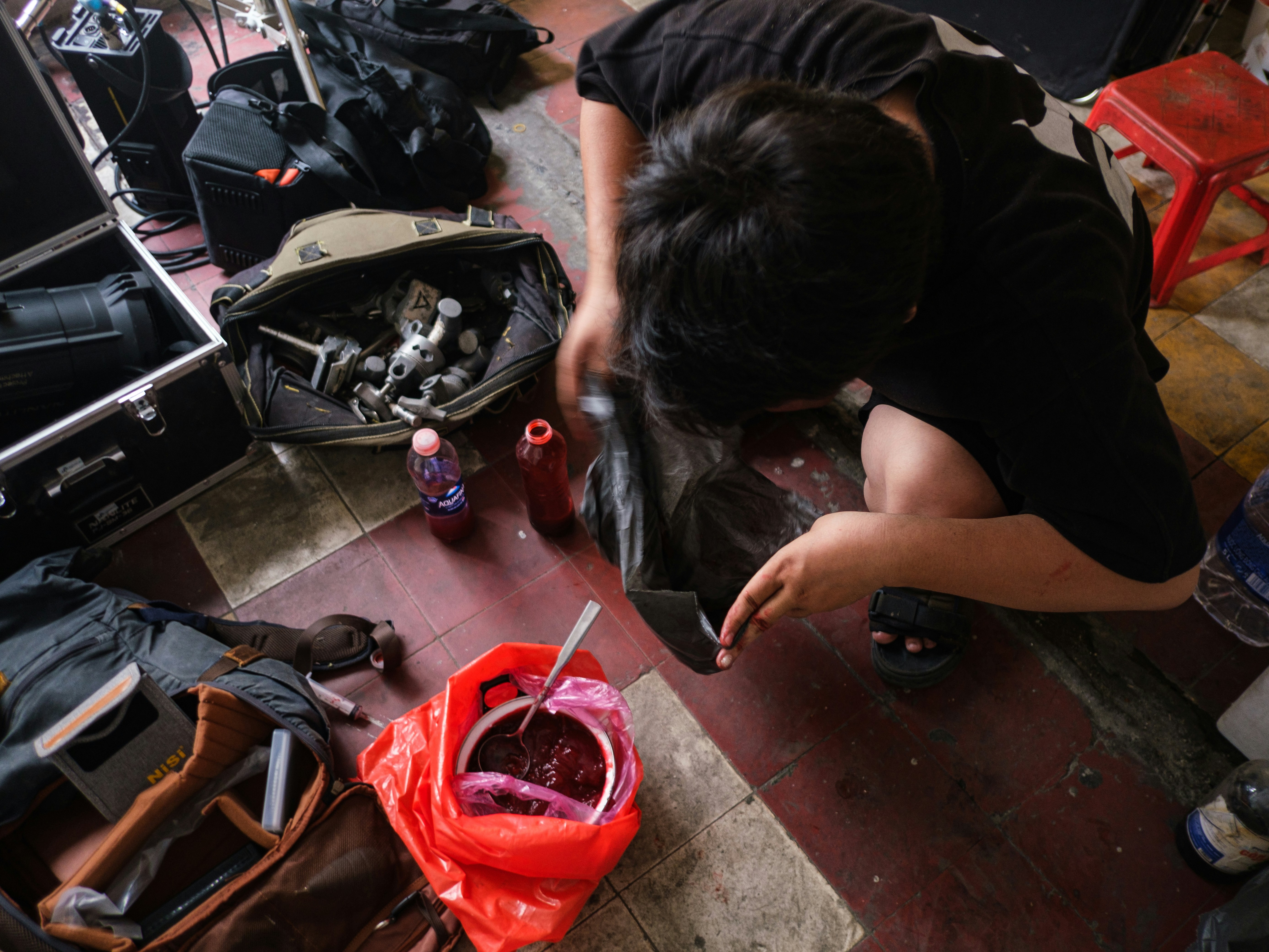 Under the Lens: a close-up on a craftsman’s hands amid tools and red-tinted dye