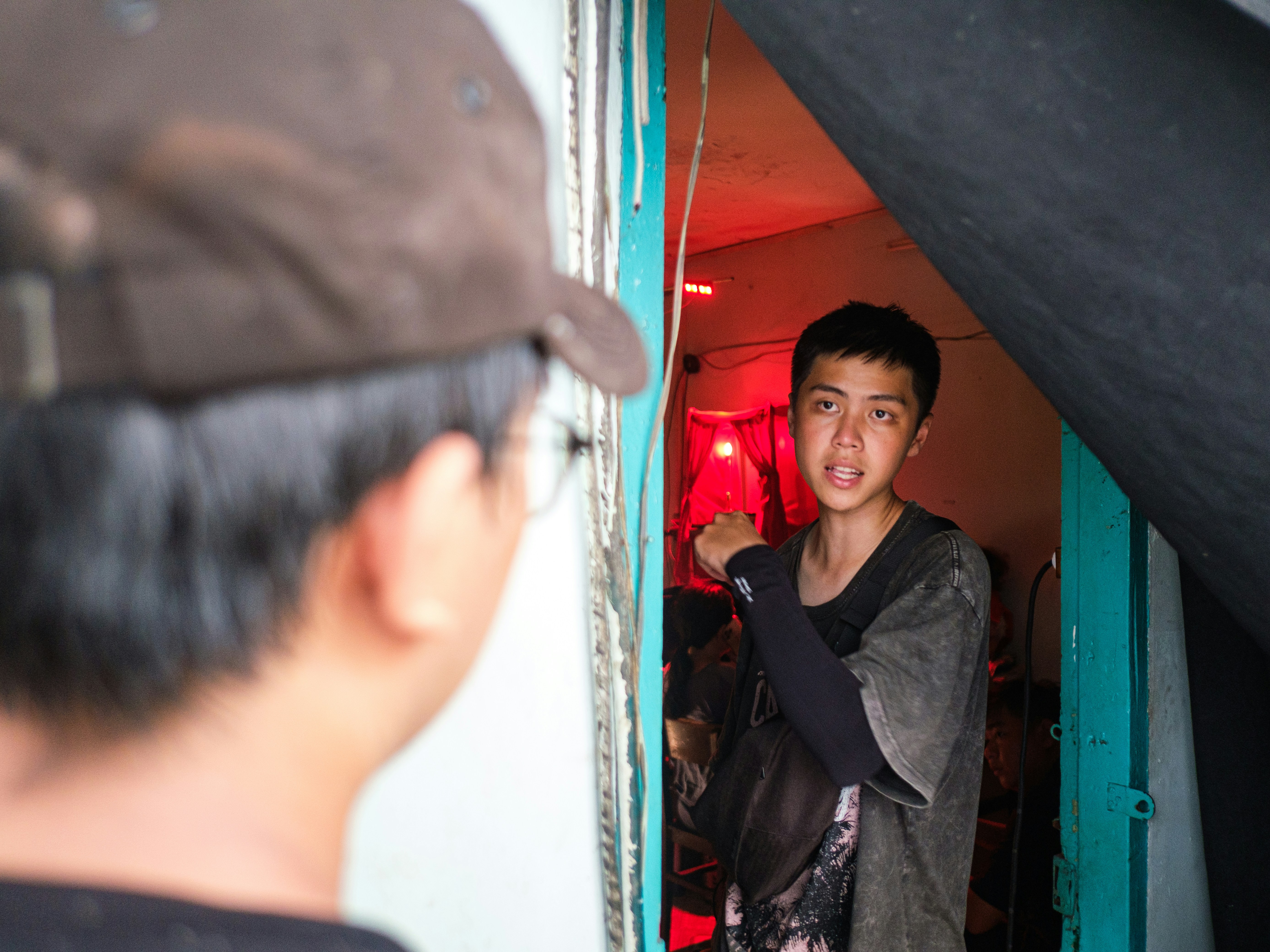 Mid-Dialogue Gaze in a Neon-Red Backroom