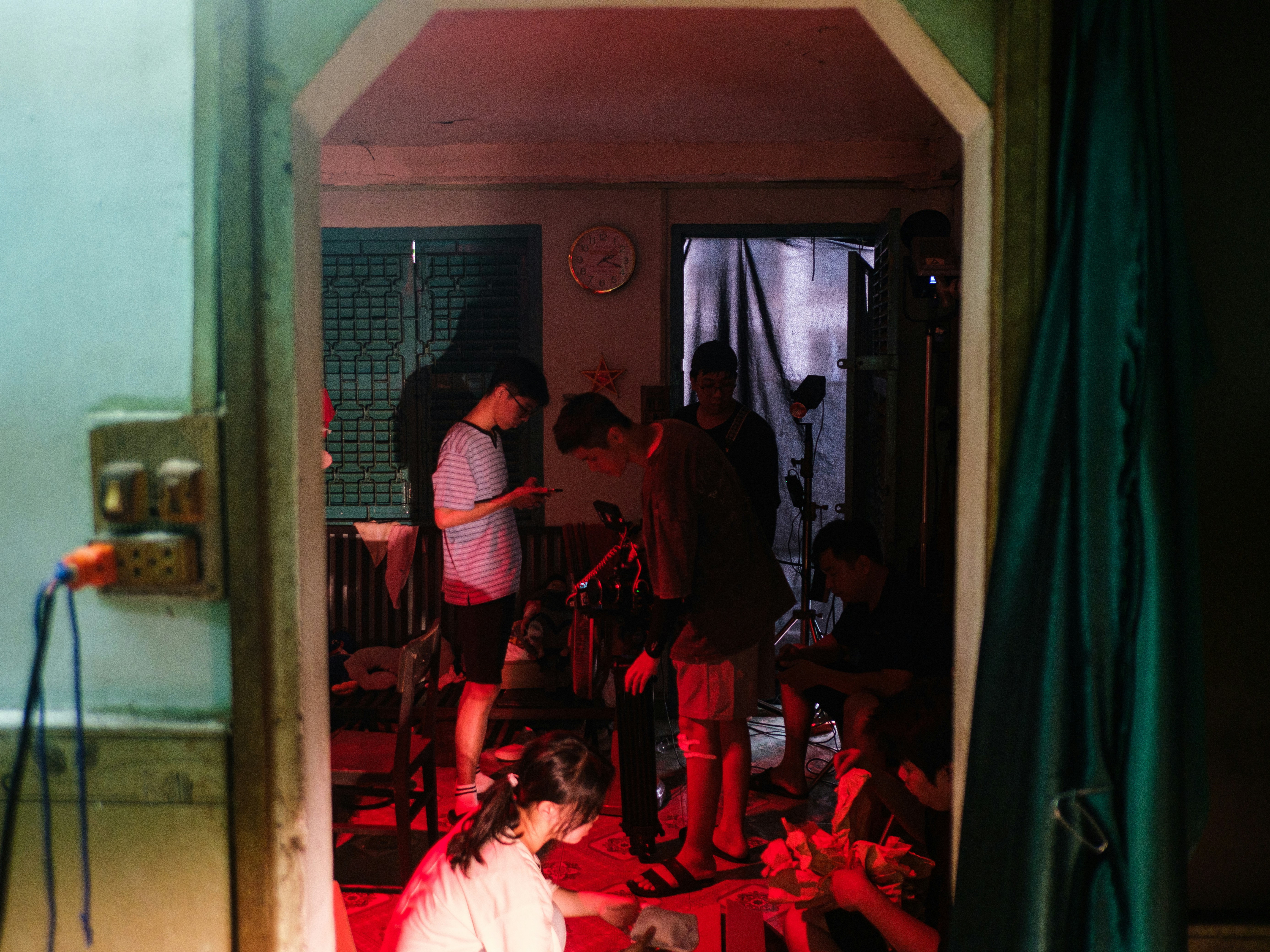 People gathered in a dimly lit room with red lighting
