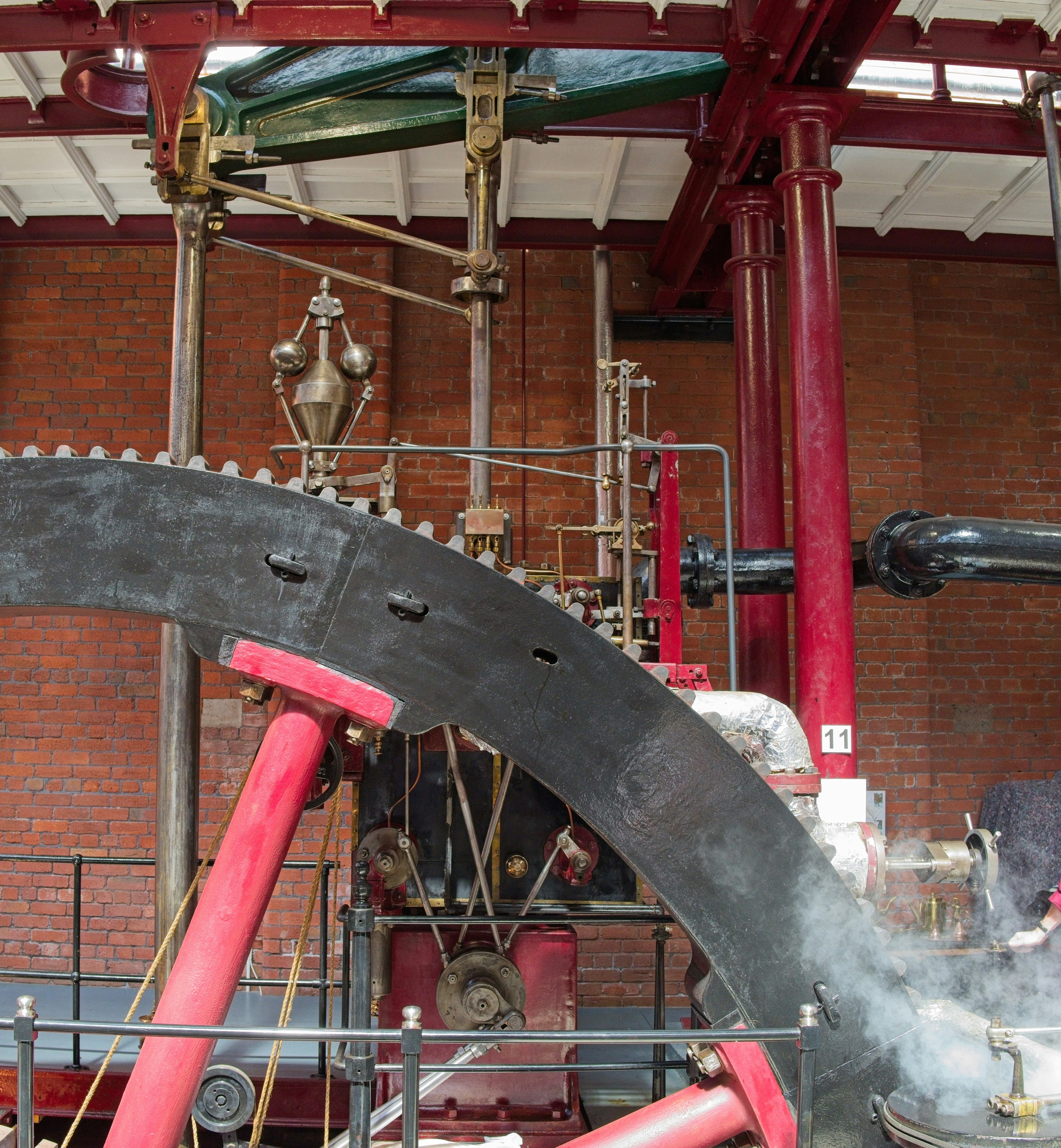 Industrial Arc: Red Supports Framing a Steam-Powered Mechanism