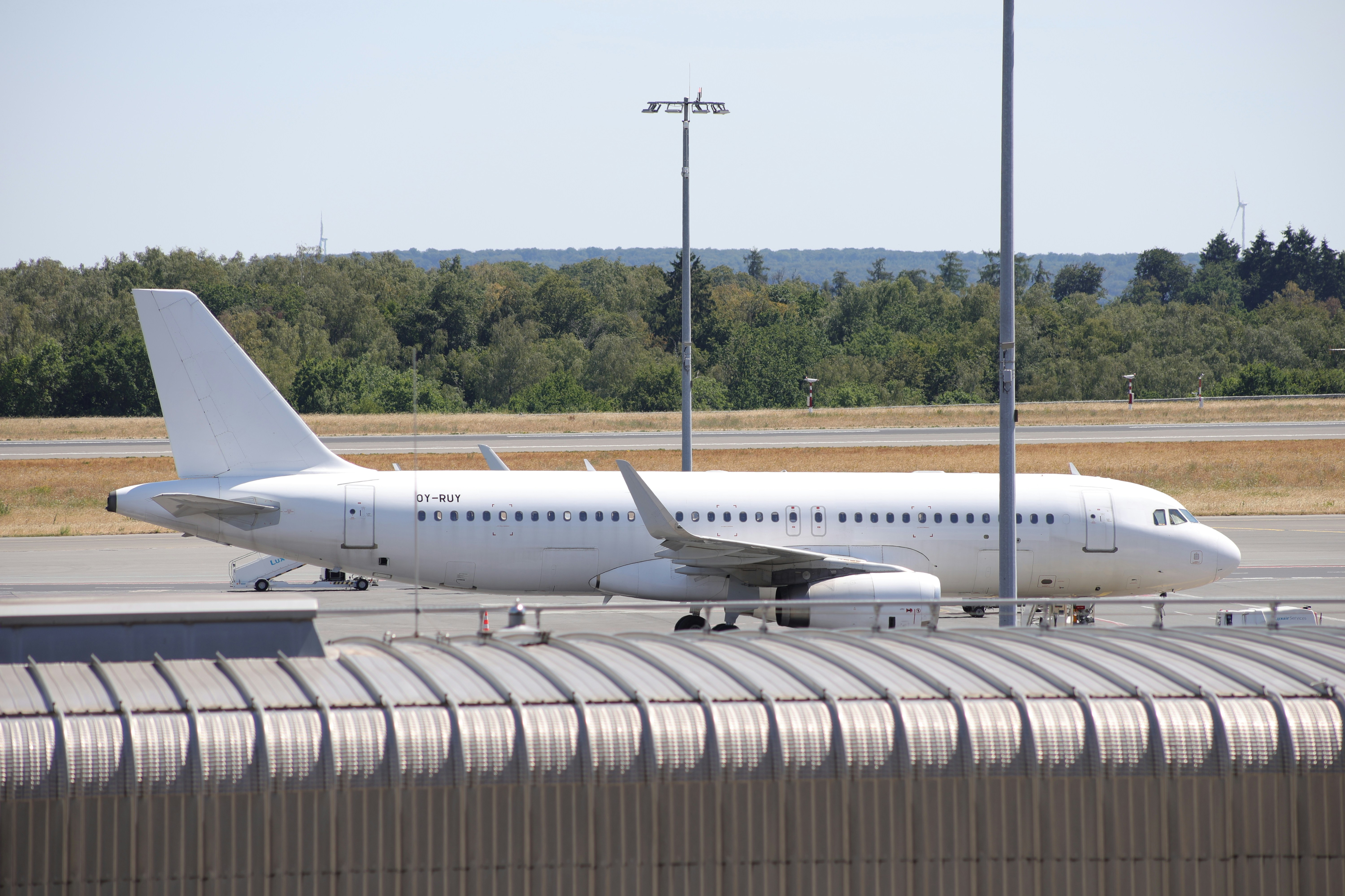 White jet on a sunlit apron with a curved barrier