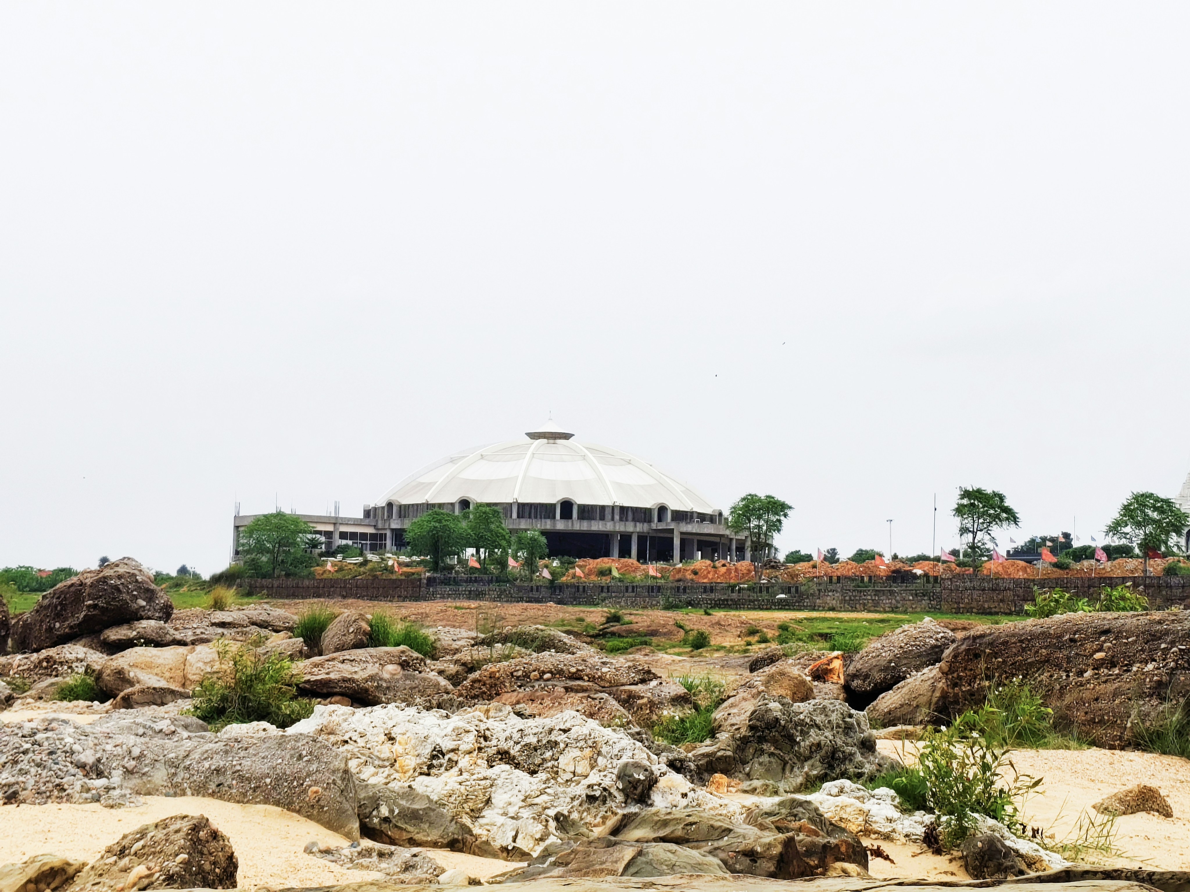Dome-Rimmed Facility Rising Beyond the Rocky Shore