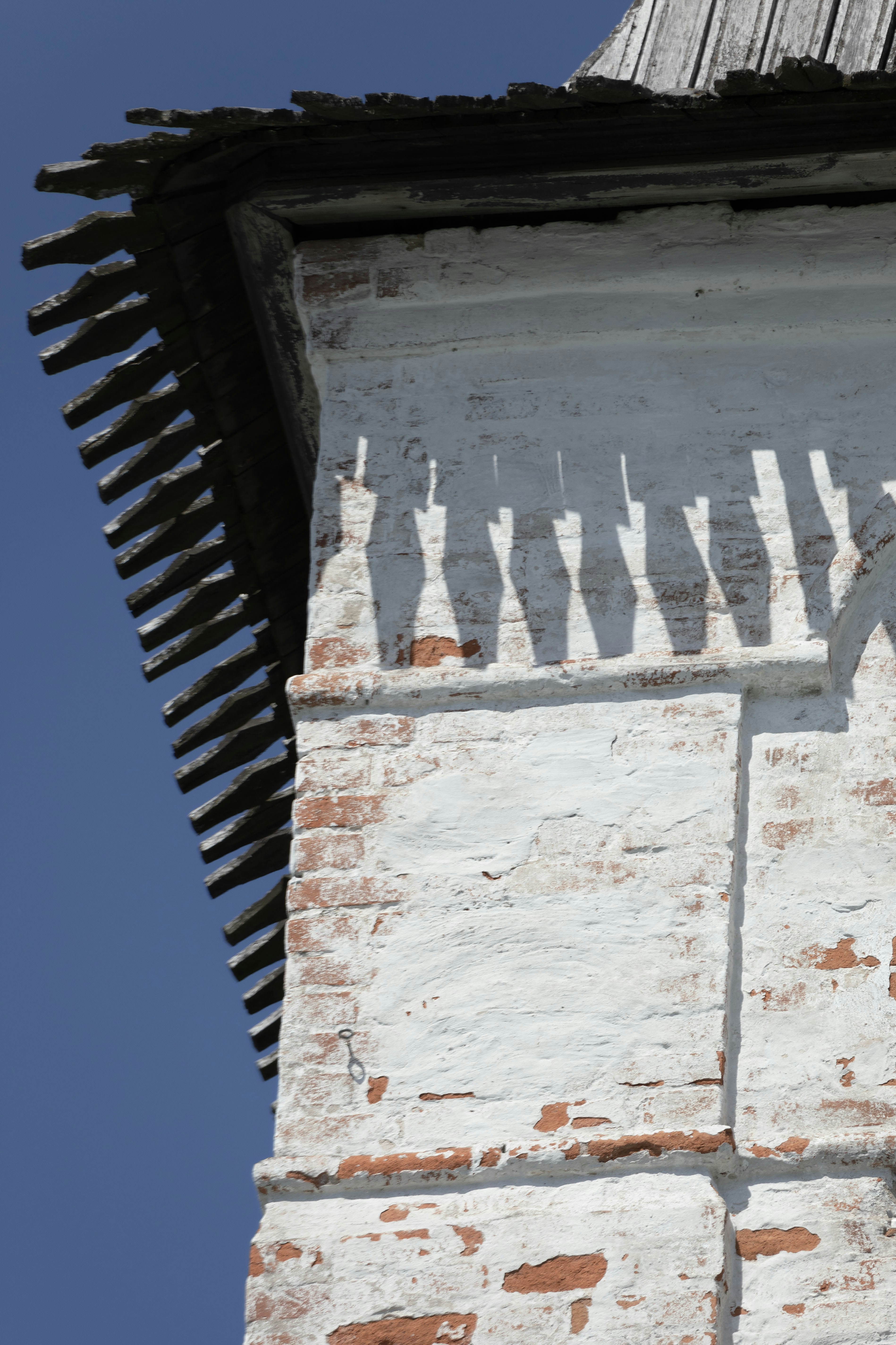 Whitewashed Corner: Weathered Bricks and Slanted Roof Silhouette
