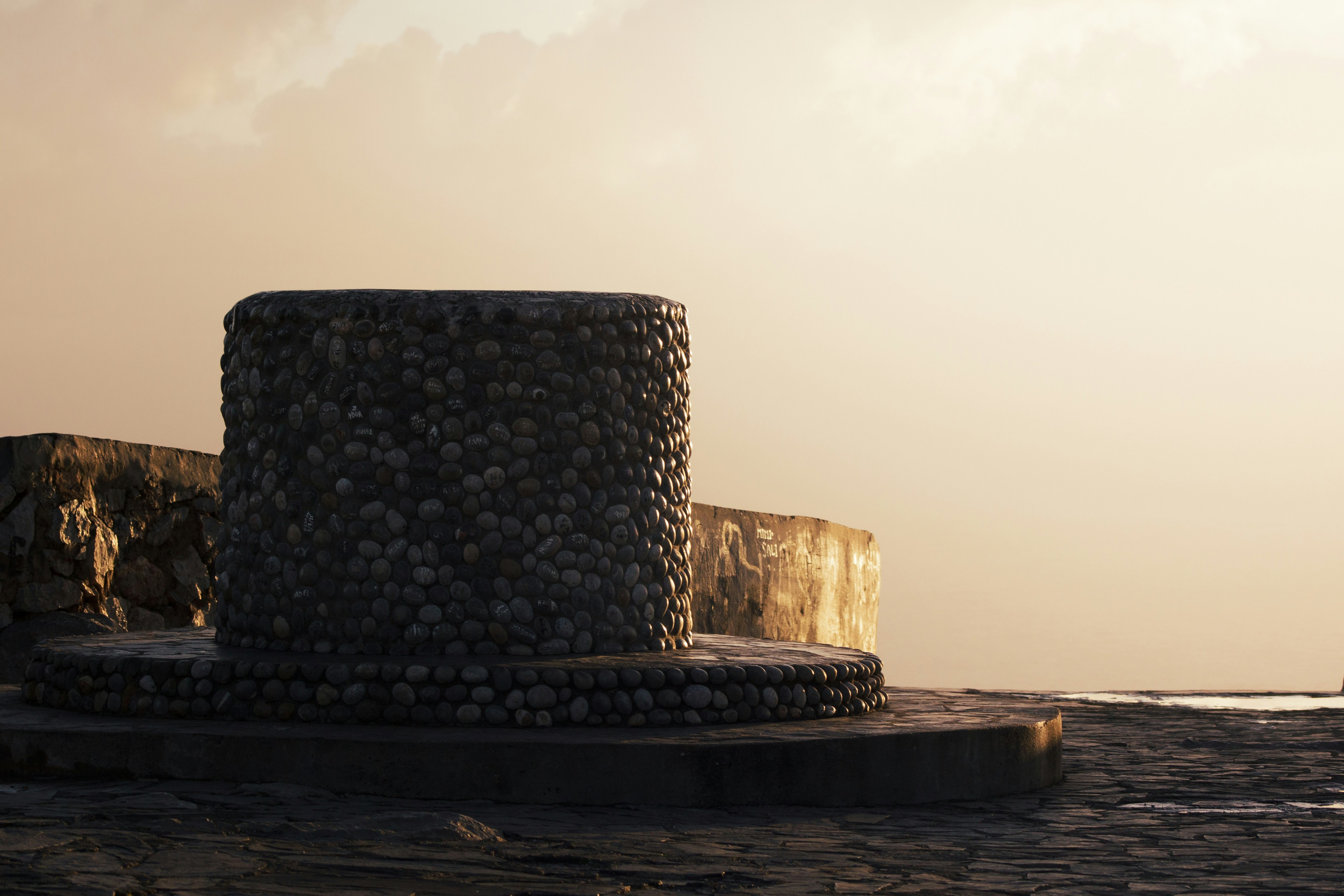Stone Cylinder by the Horizon: Quiet Sunset on the Promenade