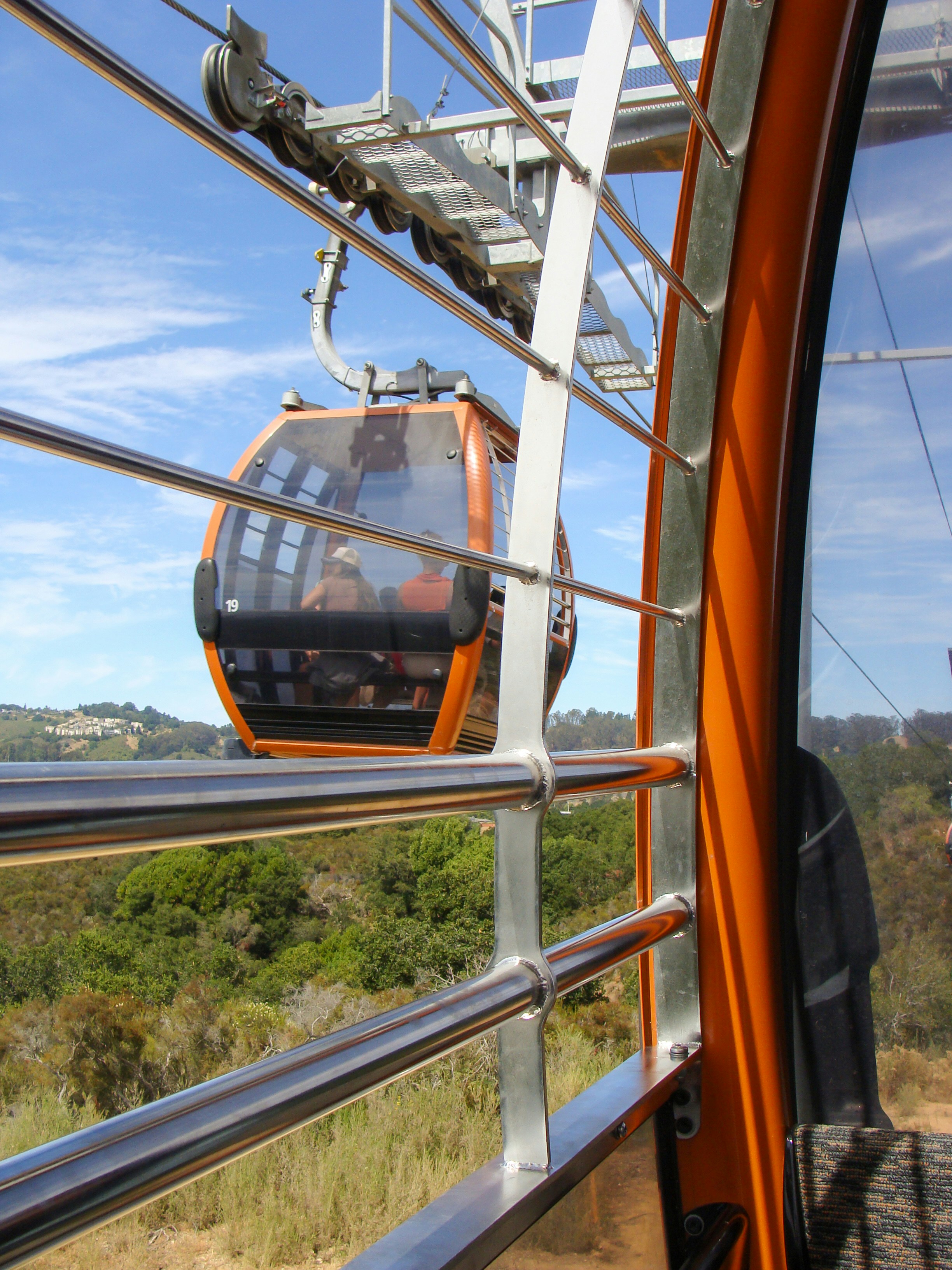 Orange Cable Car in Transit: Glimpse Through the Rails