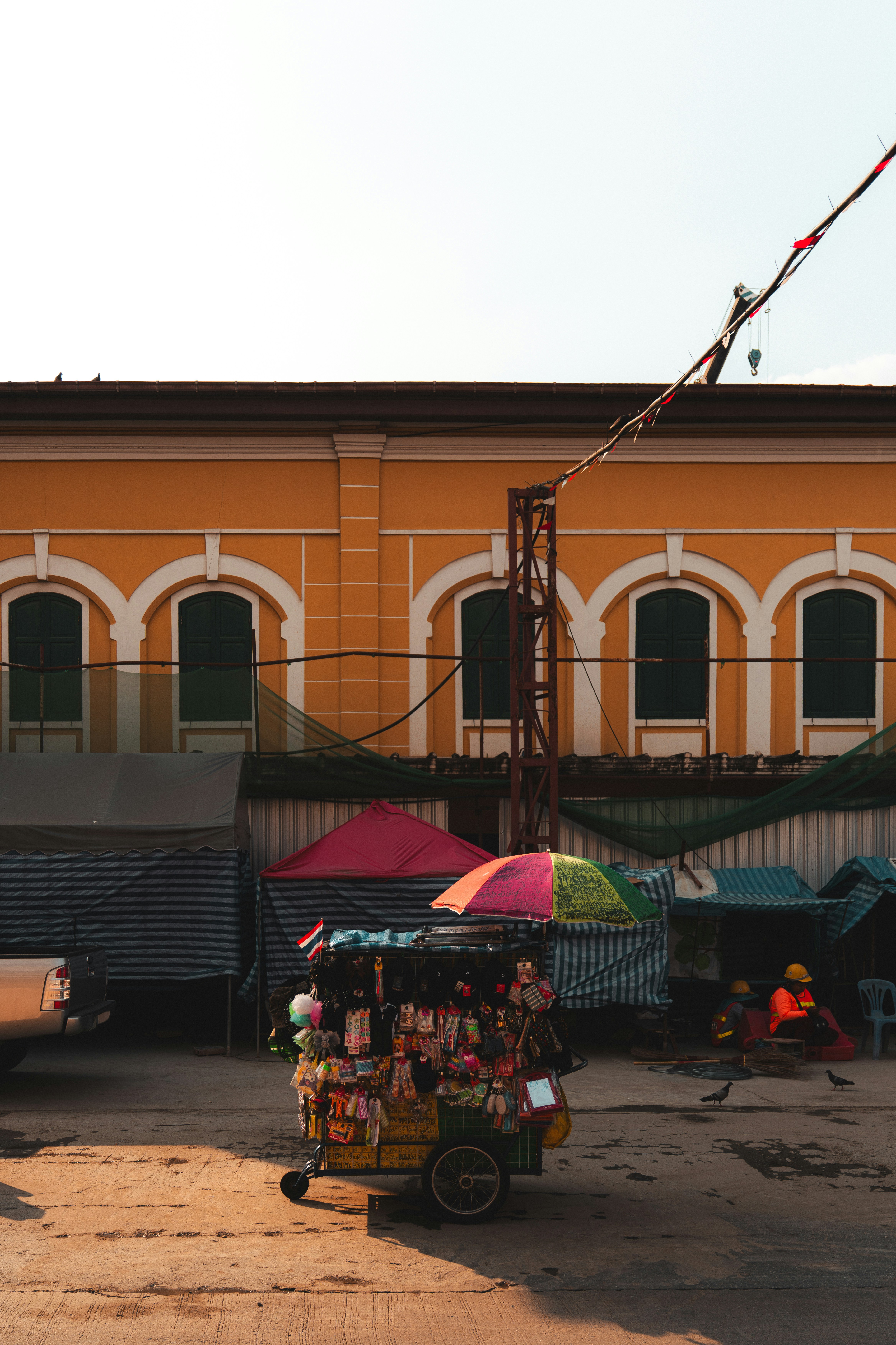 Market Cart at Dusk beneath a Sunlit Facade